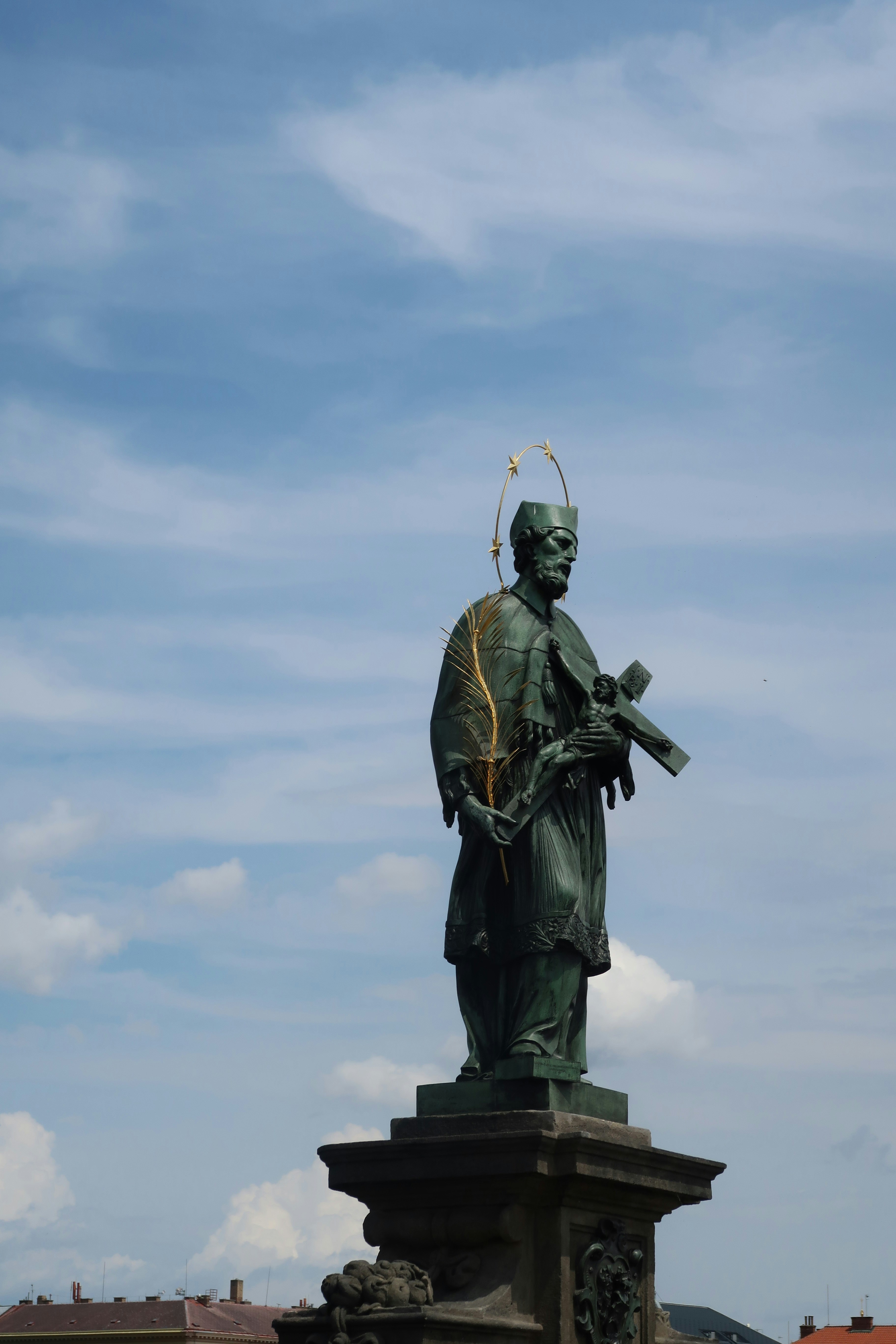 Saintly Sentinel: A Bronze Bishop Stands Against a Skyscape