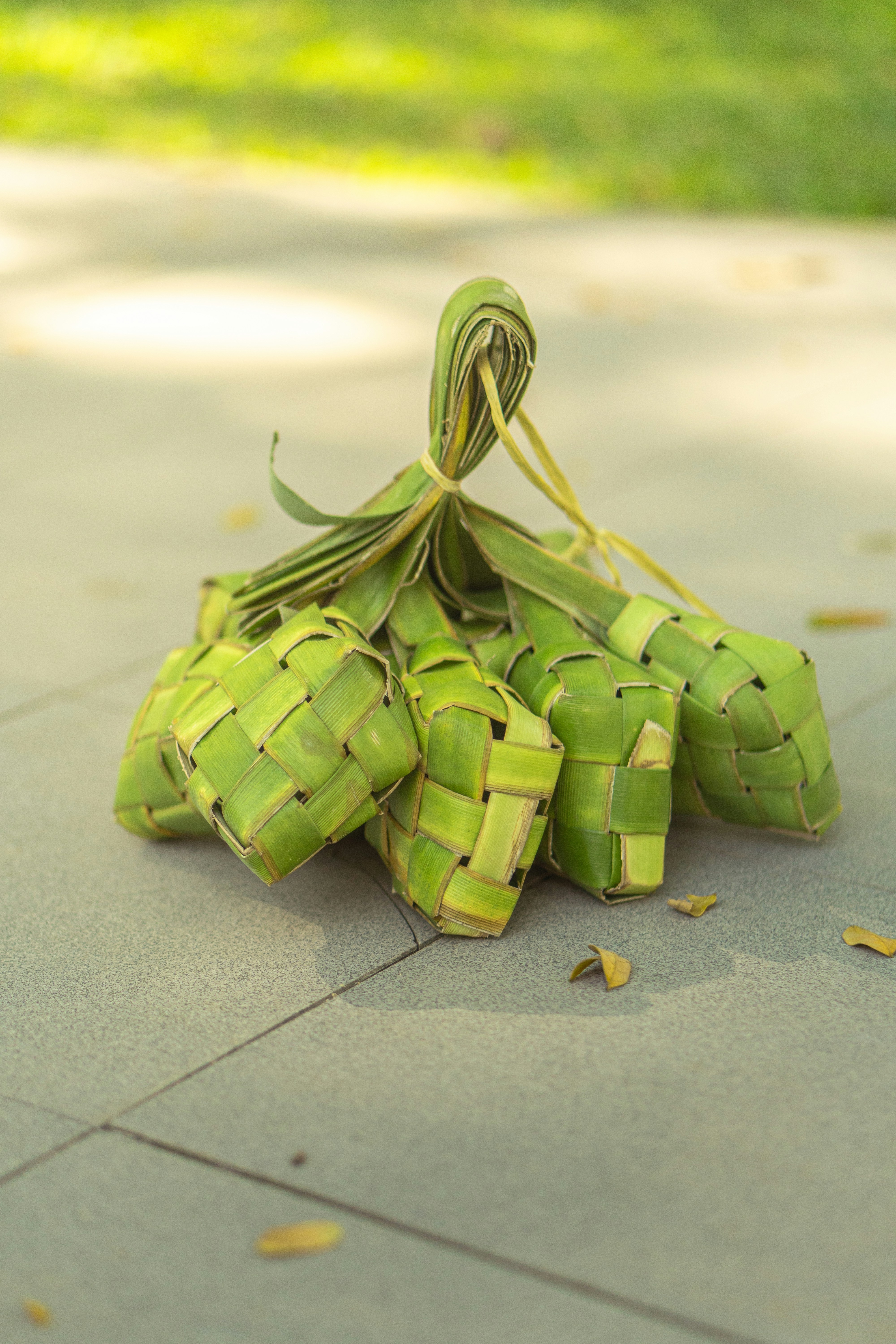 Green woven palm bundles resting on sunlit tile
