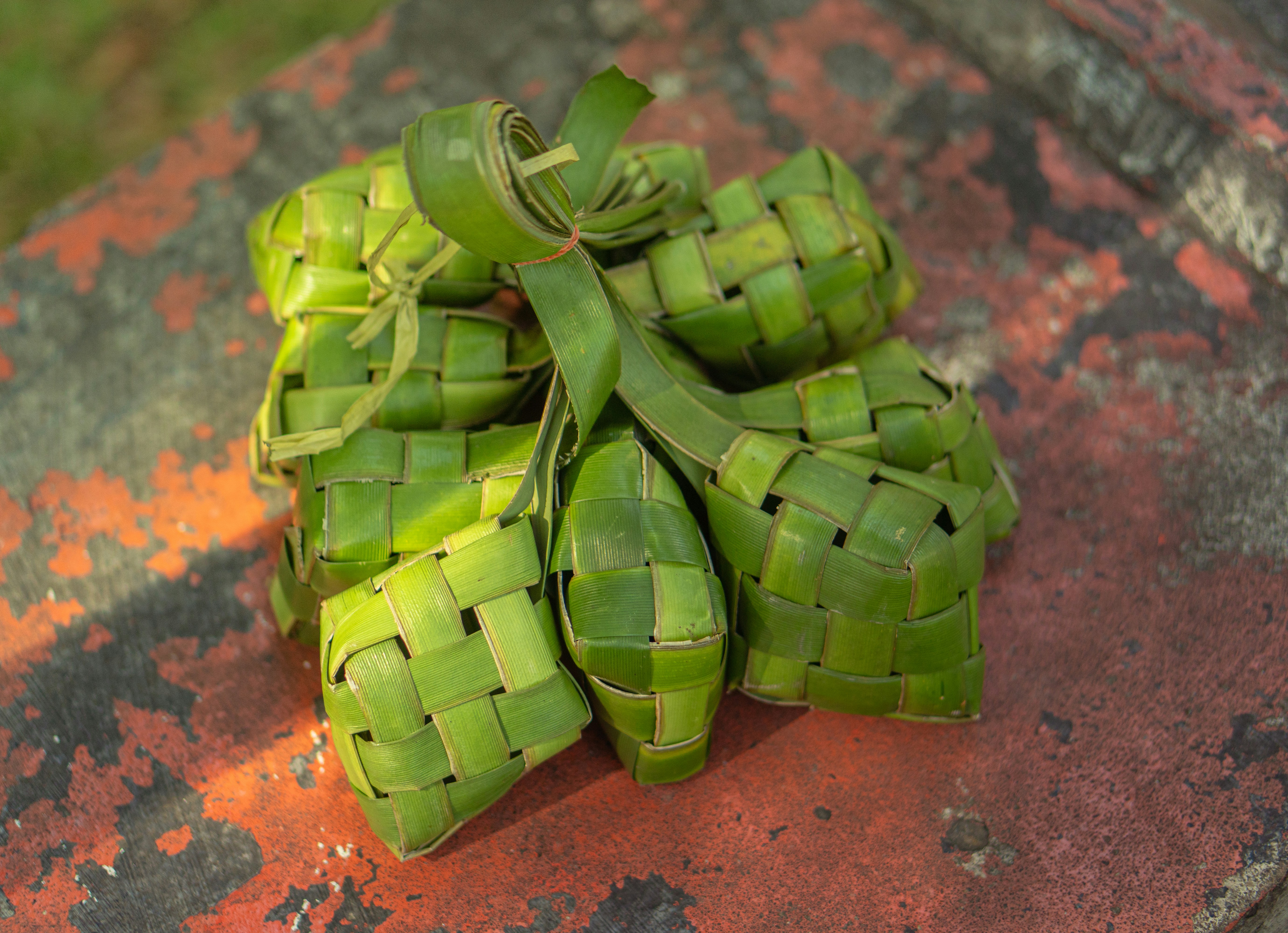 Green Weave: Handcrafted Palms Resting on a Weathered Surface