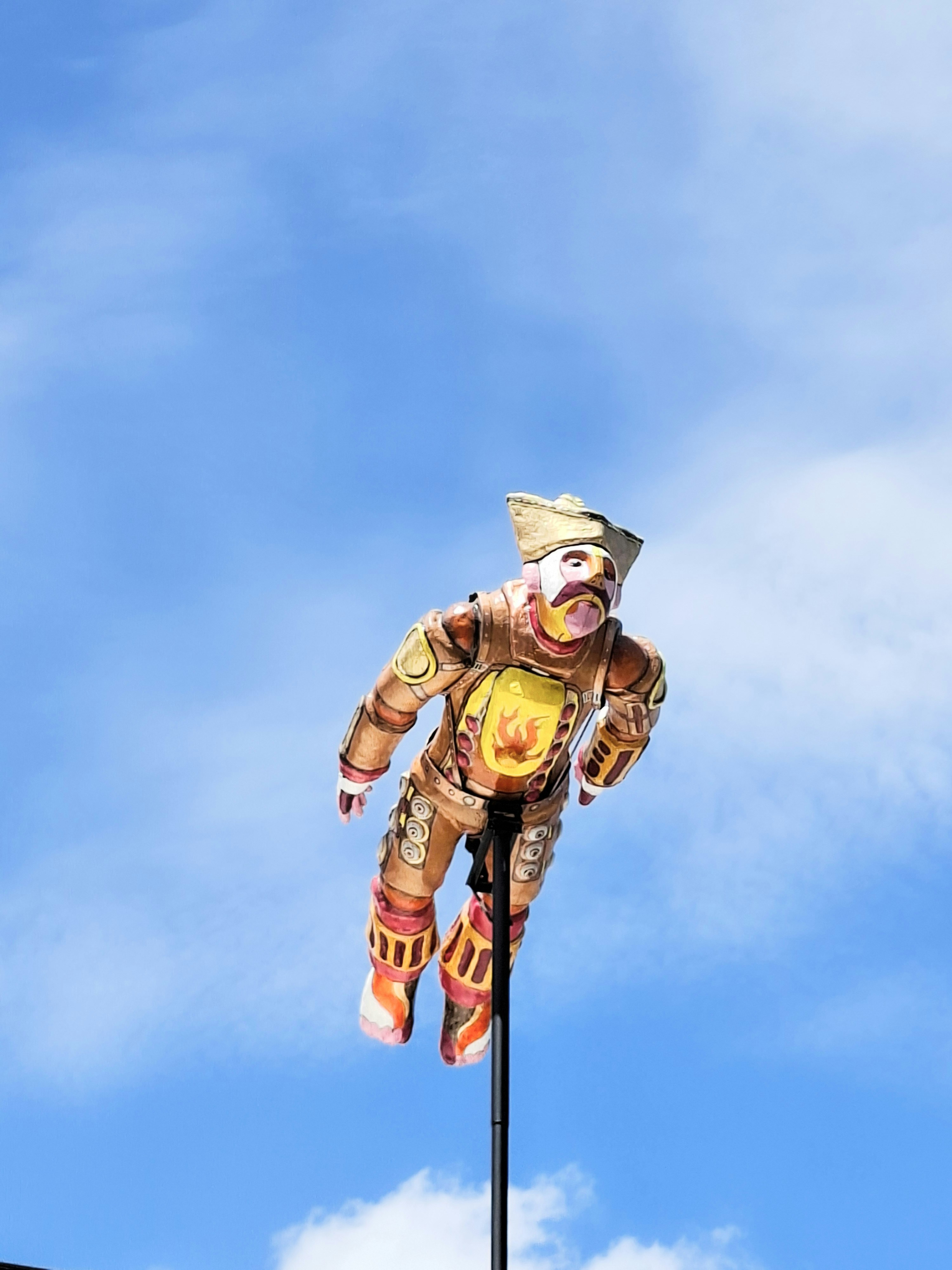 Armored Kite: A Toy Warrior Soars Against a Clear Sky