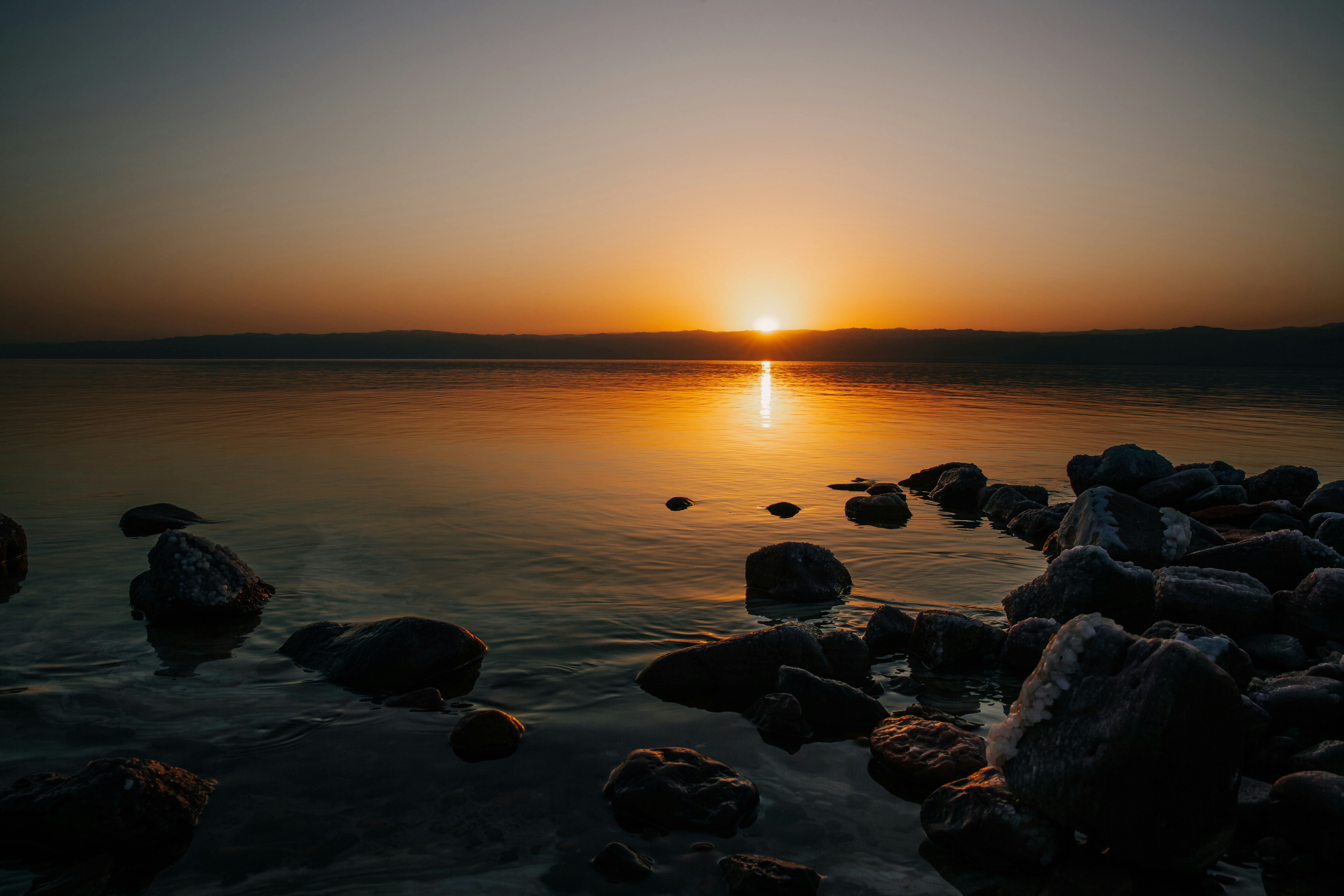 Sunlit Rift: Calm Waters Meet a Rocky Shore at Dusk