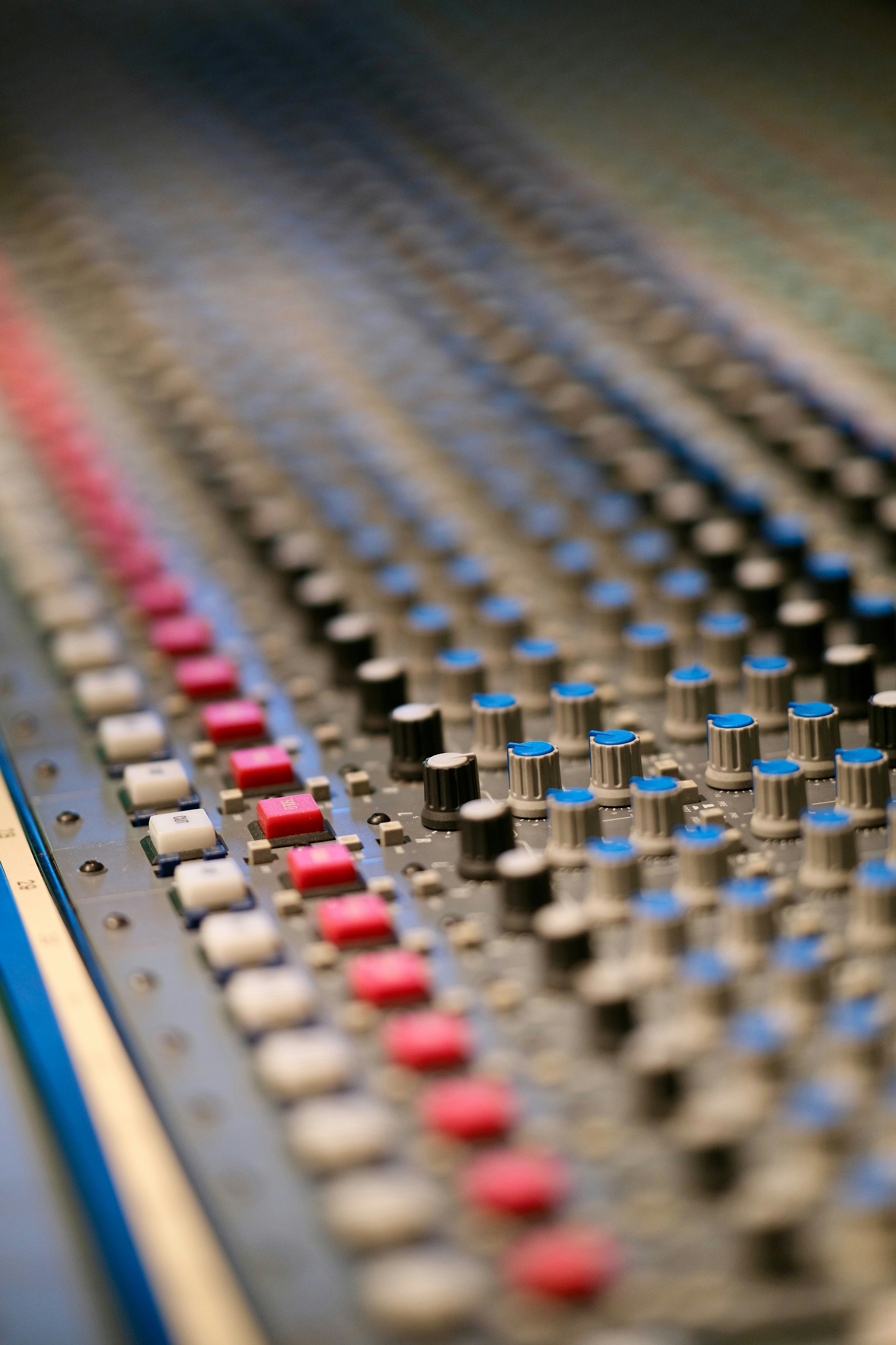 Blue Knobs and Colored Faders on a Studio Mixing Console