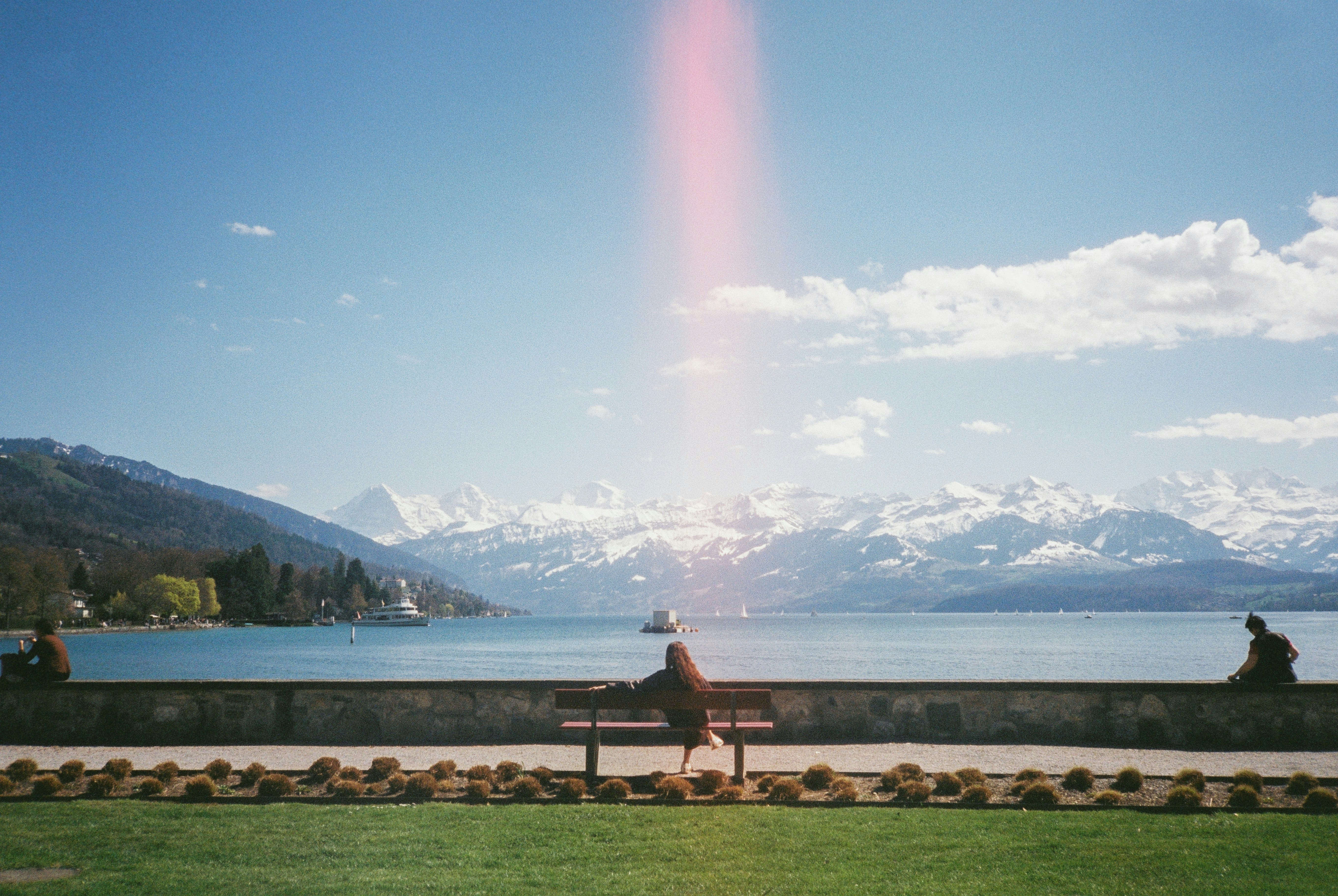 Lakeside Calm: Bench, Seascape, and Snow-Capped Majesty