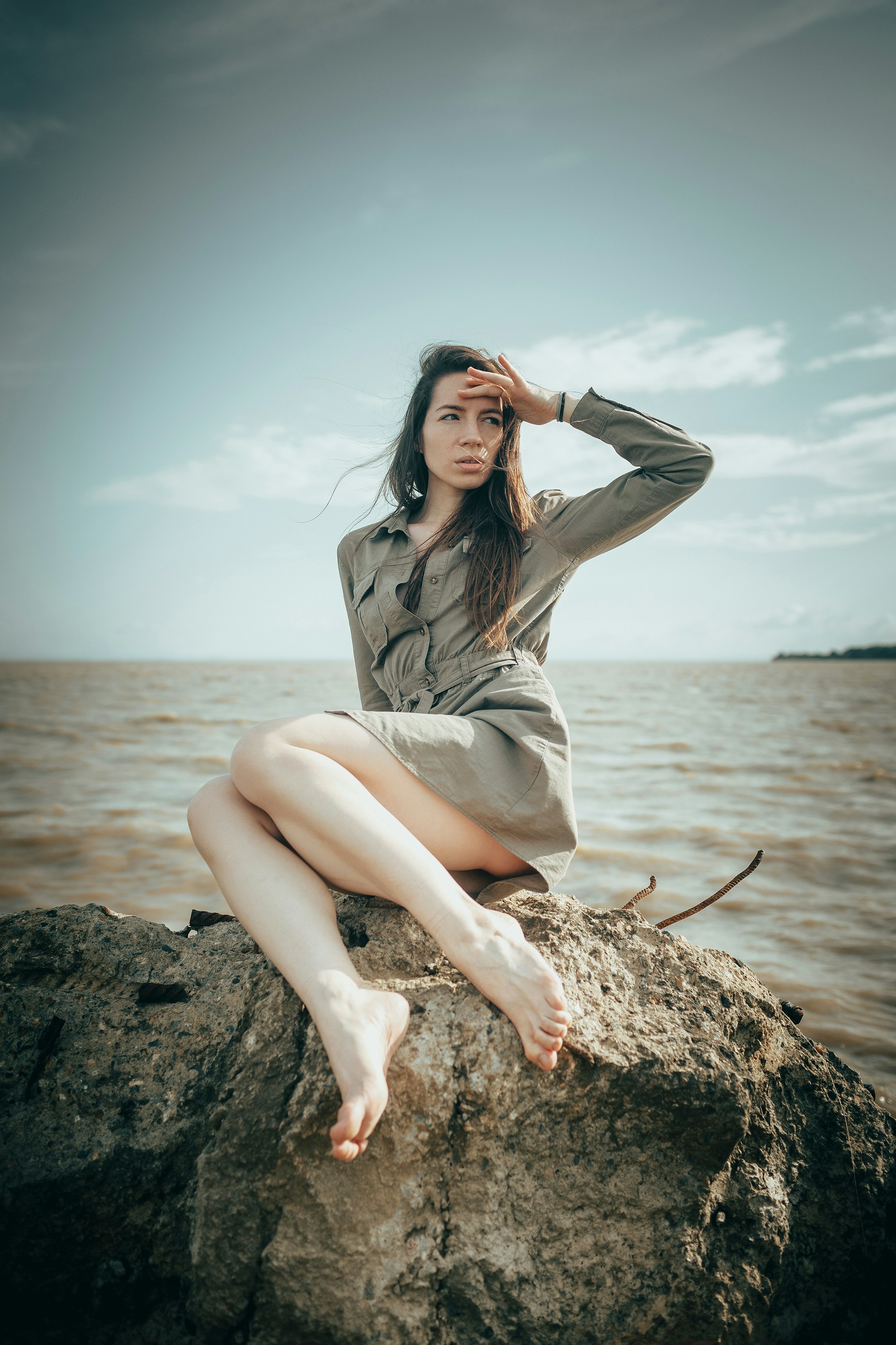 Sea-salted Serenity: a lone figure perched on rugged rock beneath a sky
