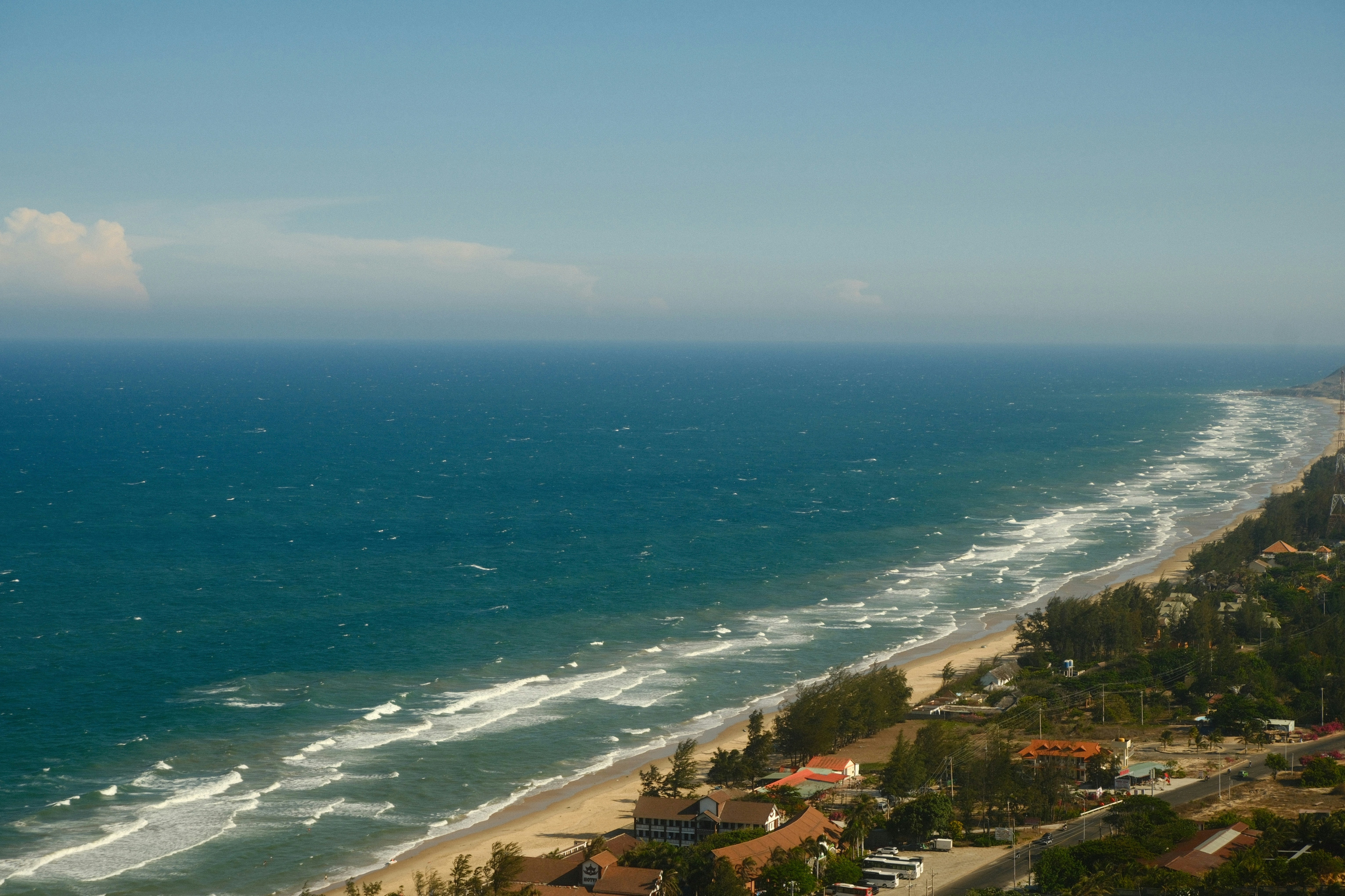 Coastal Terrace: Aerial view of a sunlit shoreline and seaside neighborhood