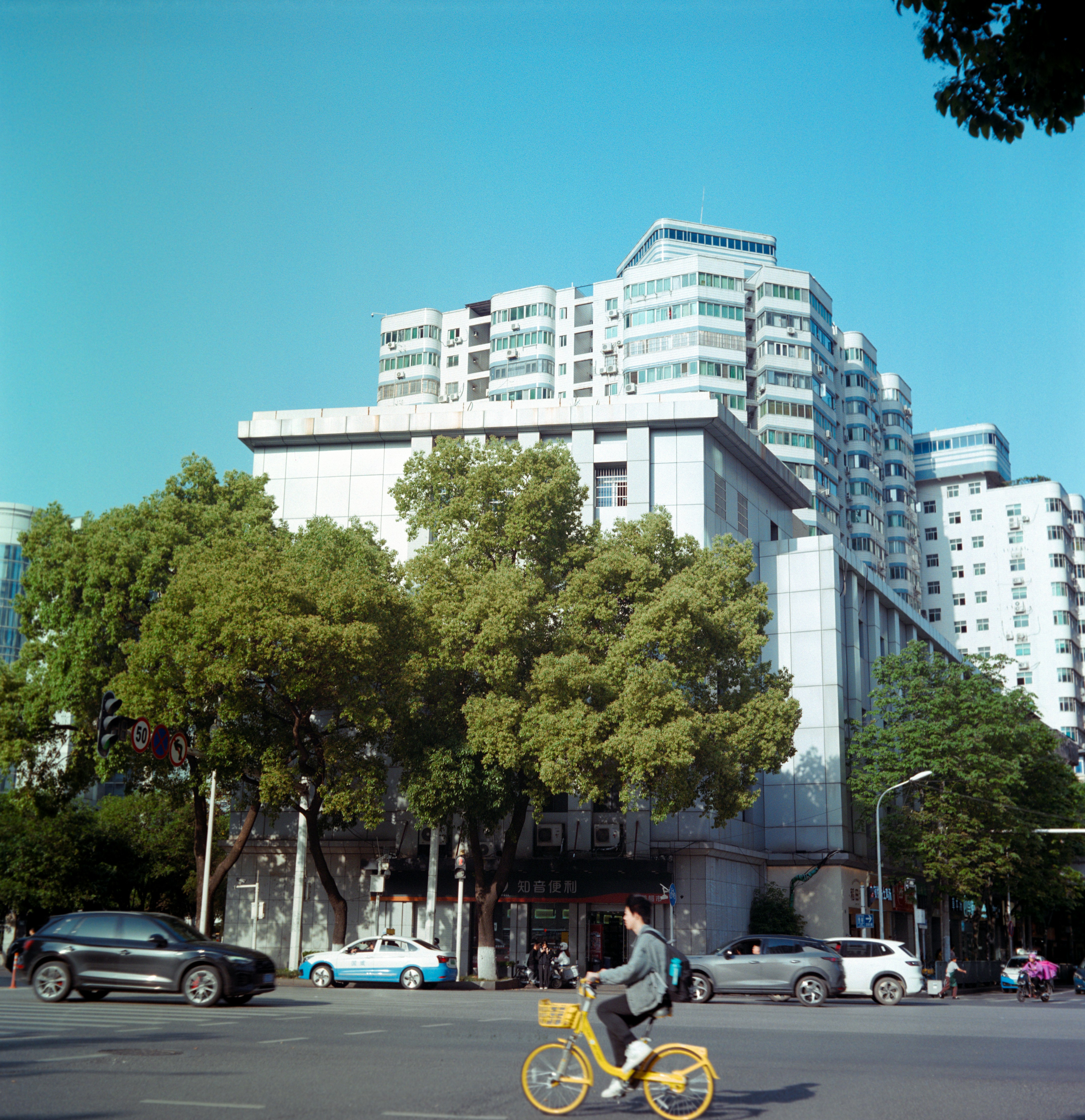 City Block in Motion: A Yellow Bicycle Crossing the Street