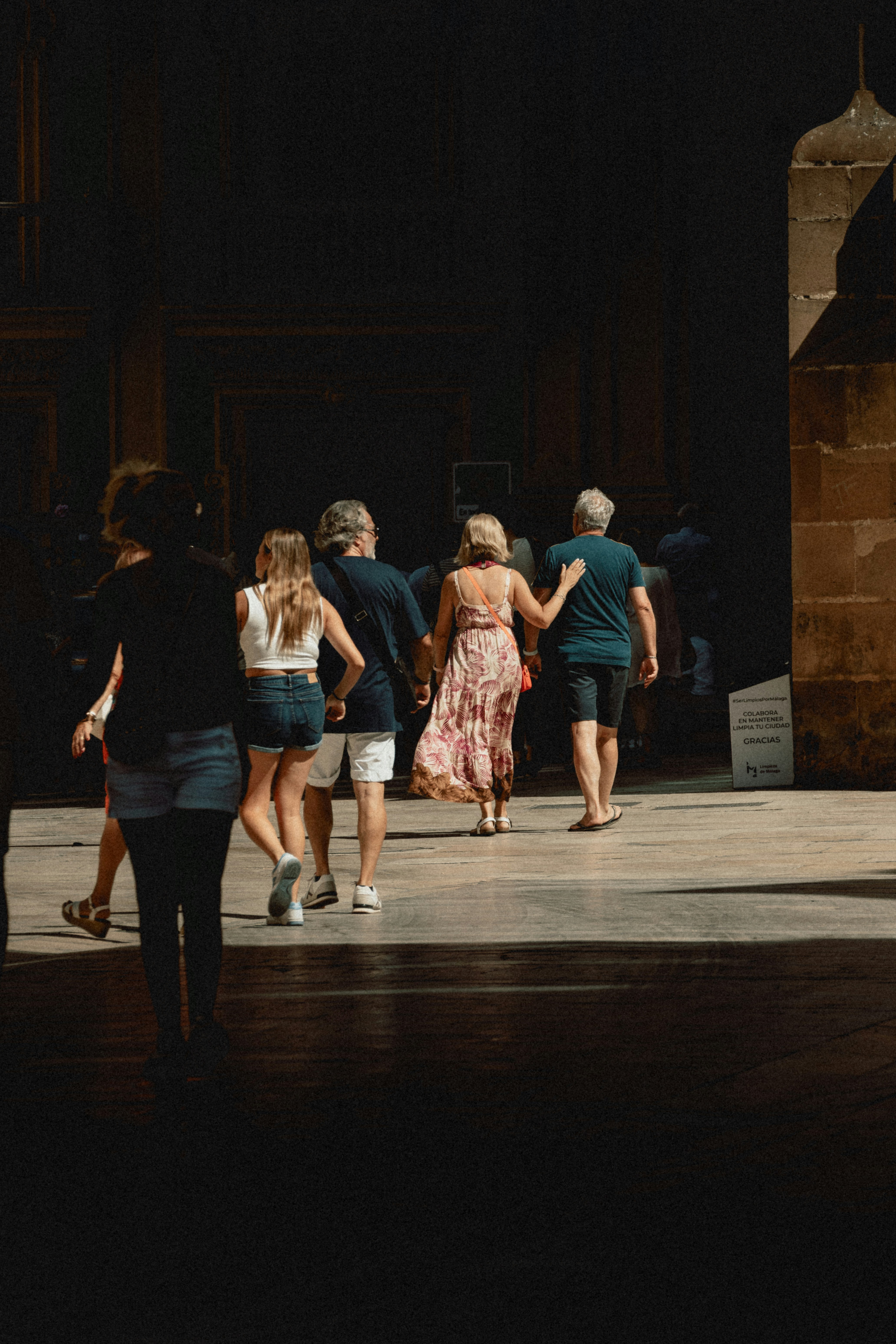 Sunlit Exit: A Small Group Walks Toward the Cathedral Ambience