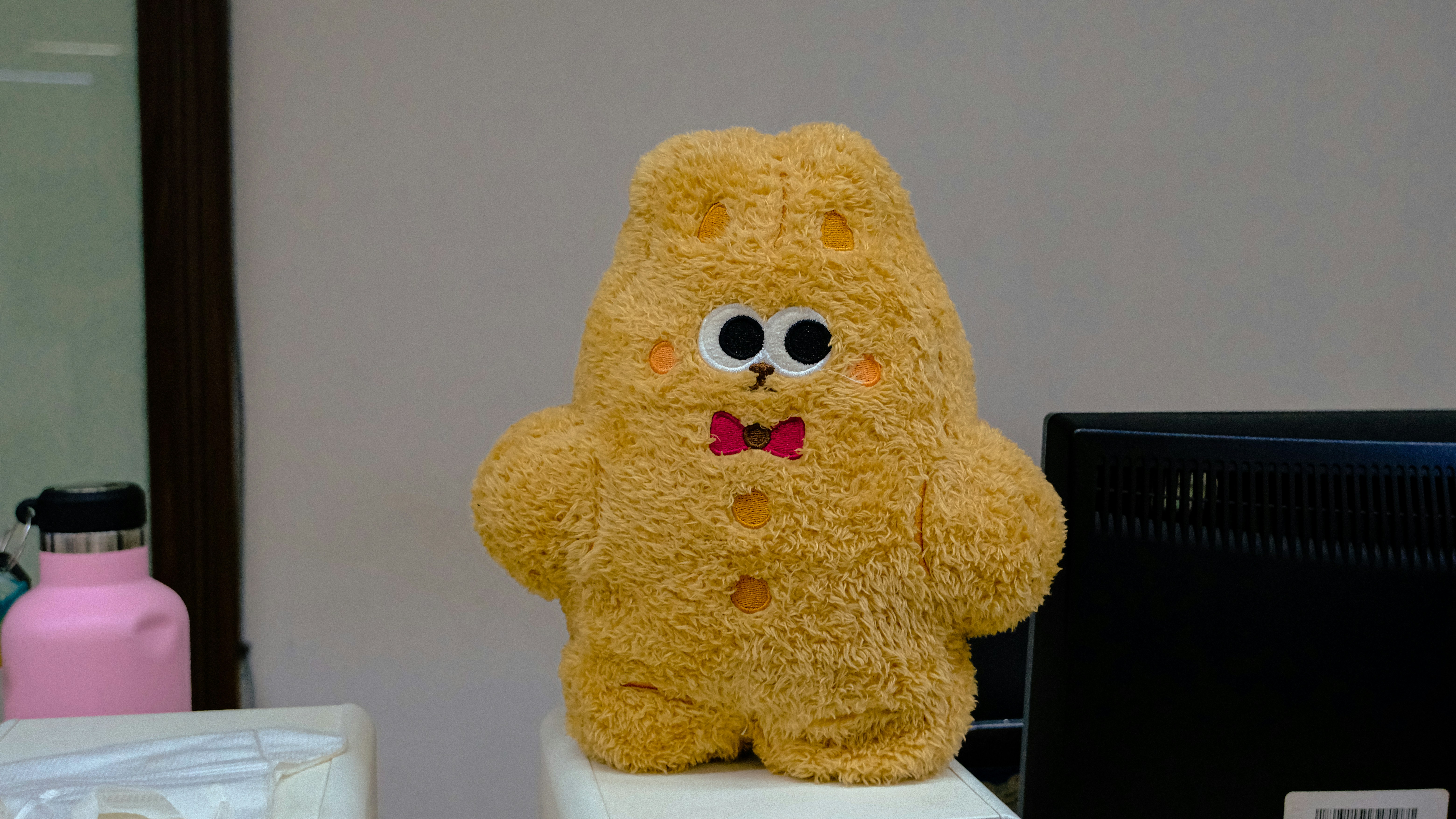 Sunshiny Squiggle: A friendly plush stands by a monitor