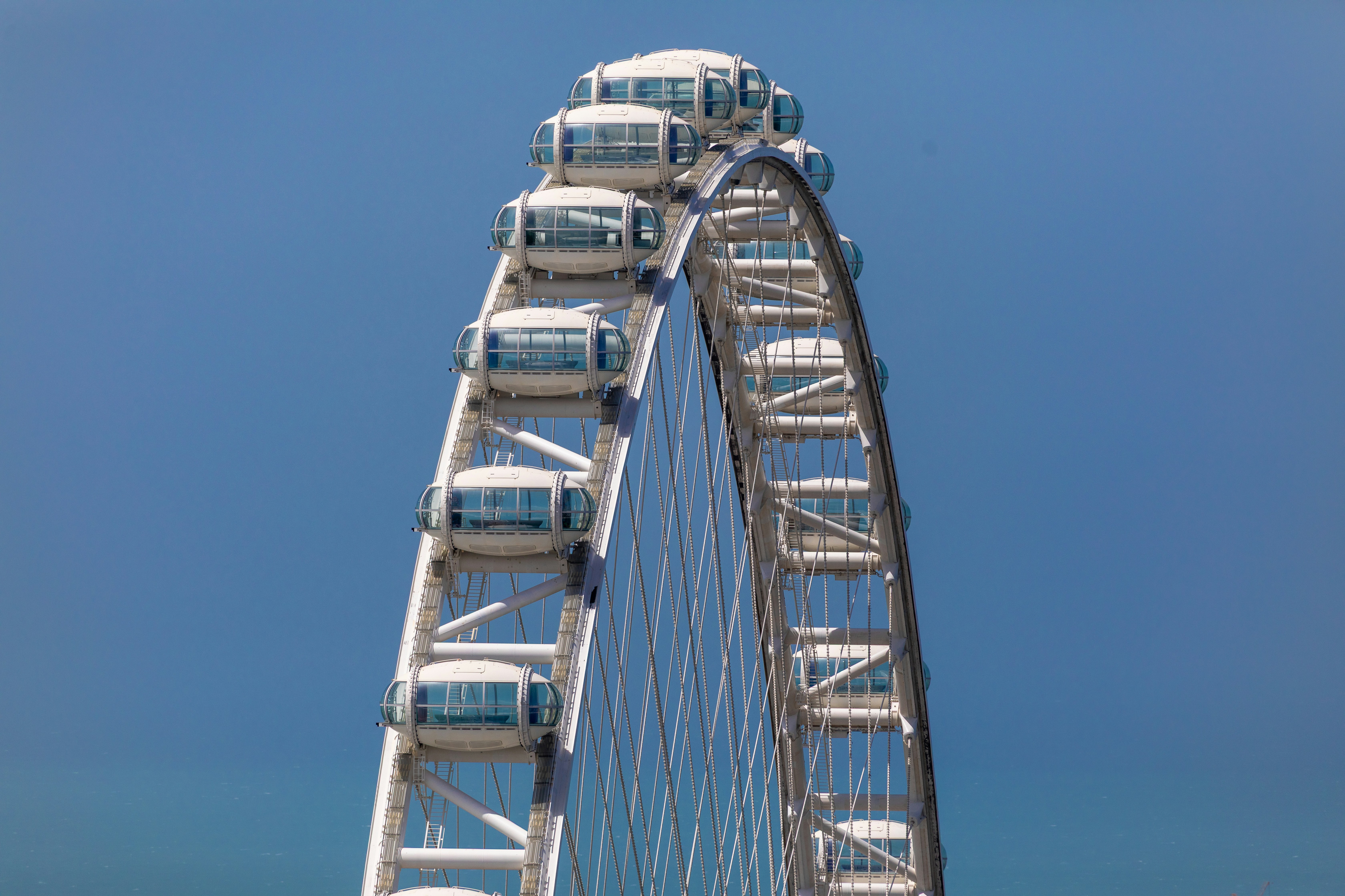High Above the Waves: A Ferris Wheel Carries the Blue Horizon