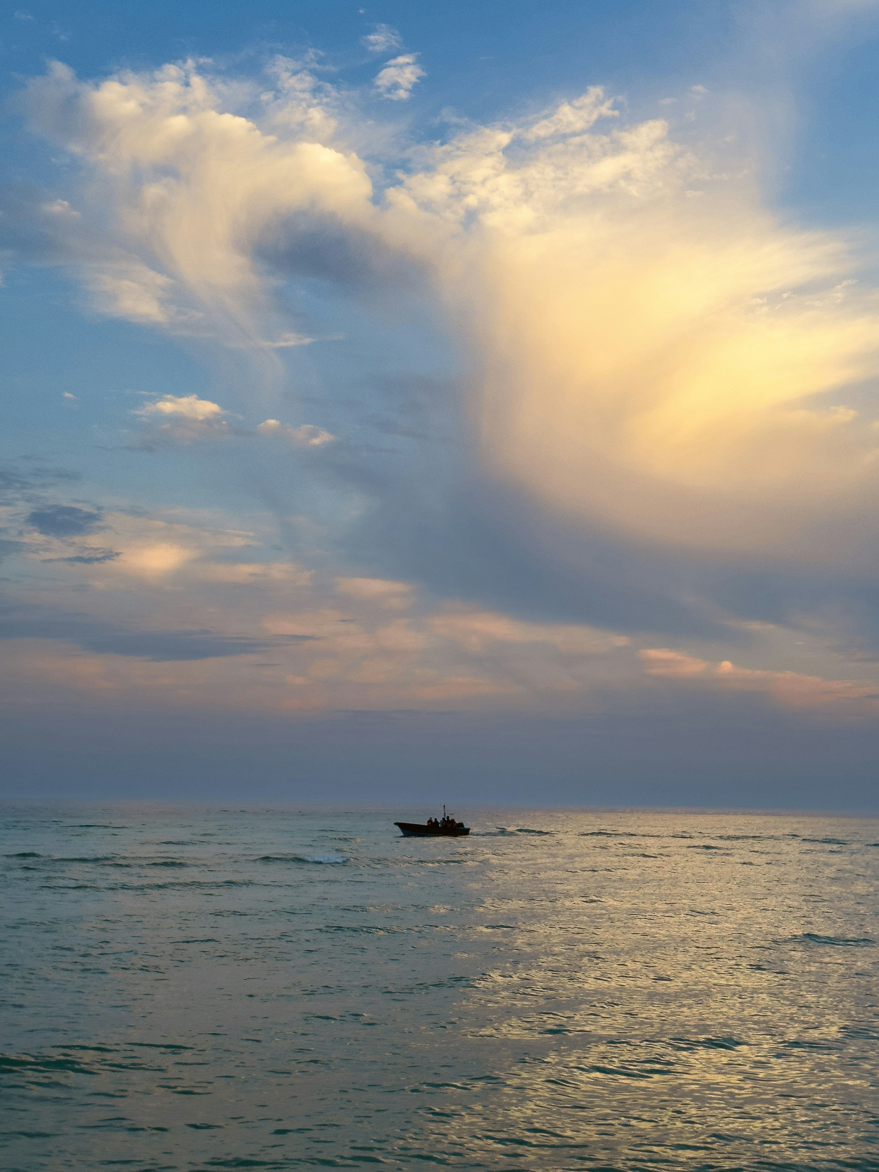 Calm Horizon: A Distant Boat Beneath A Painted Sky