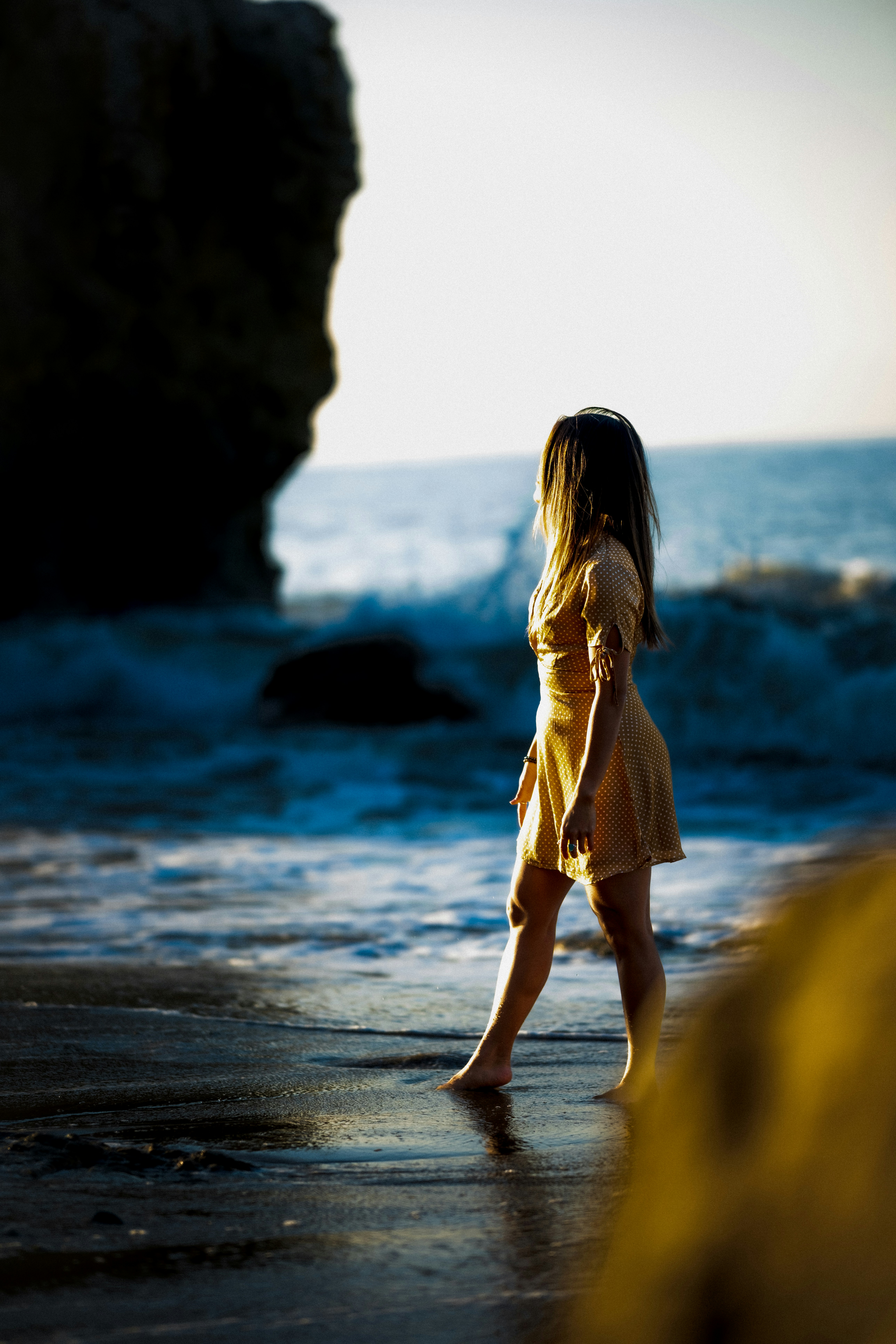 Coastline Silhouette: A Solitary Walk Along Sunlit Shore