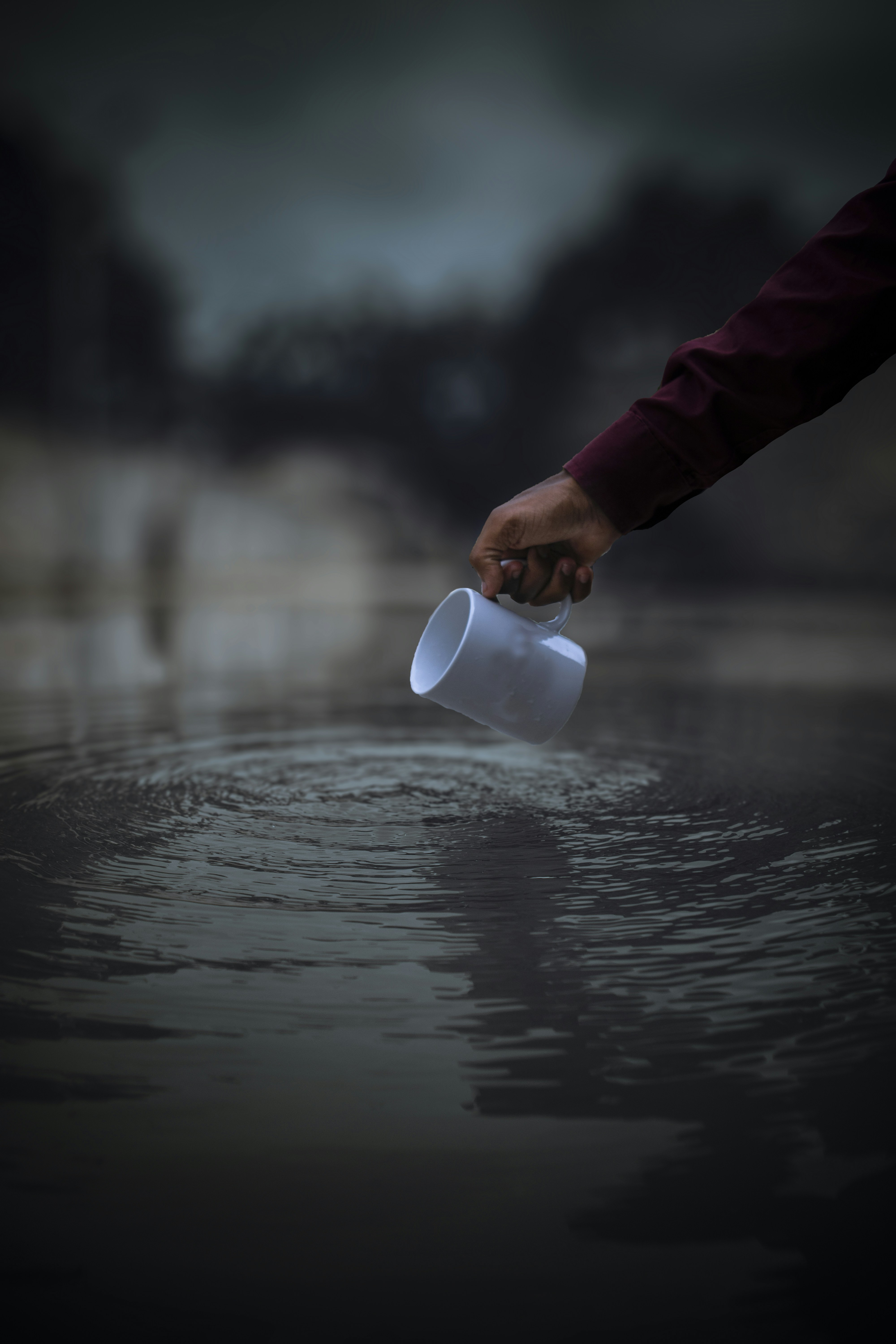 A Delicate Pour: White Cup Skimming Across Quiet Ripples