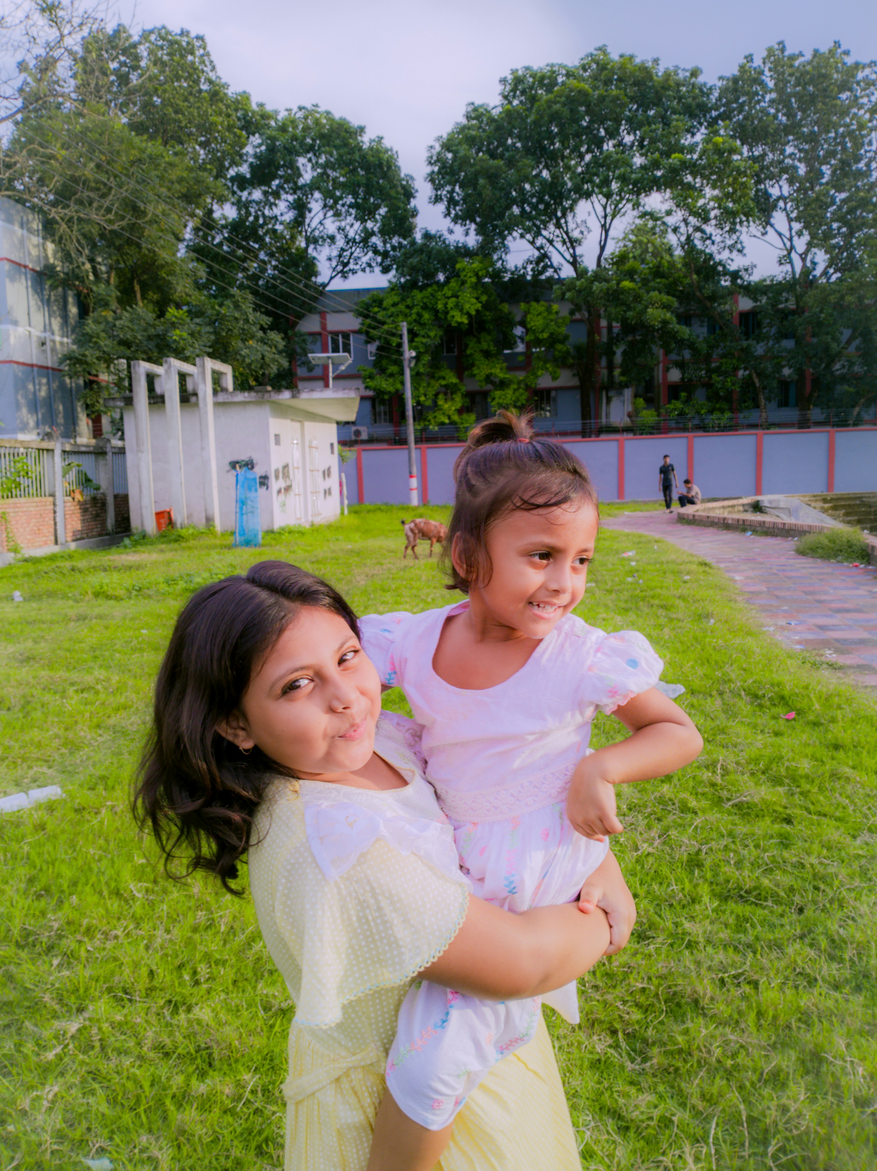 Sisters in a Sunlit Park: A Moment of Tender Joy