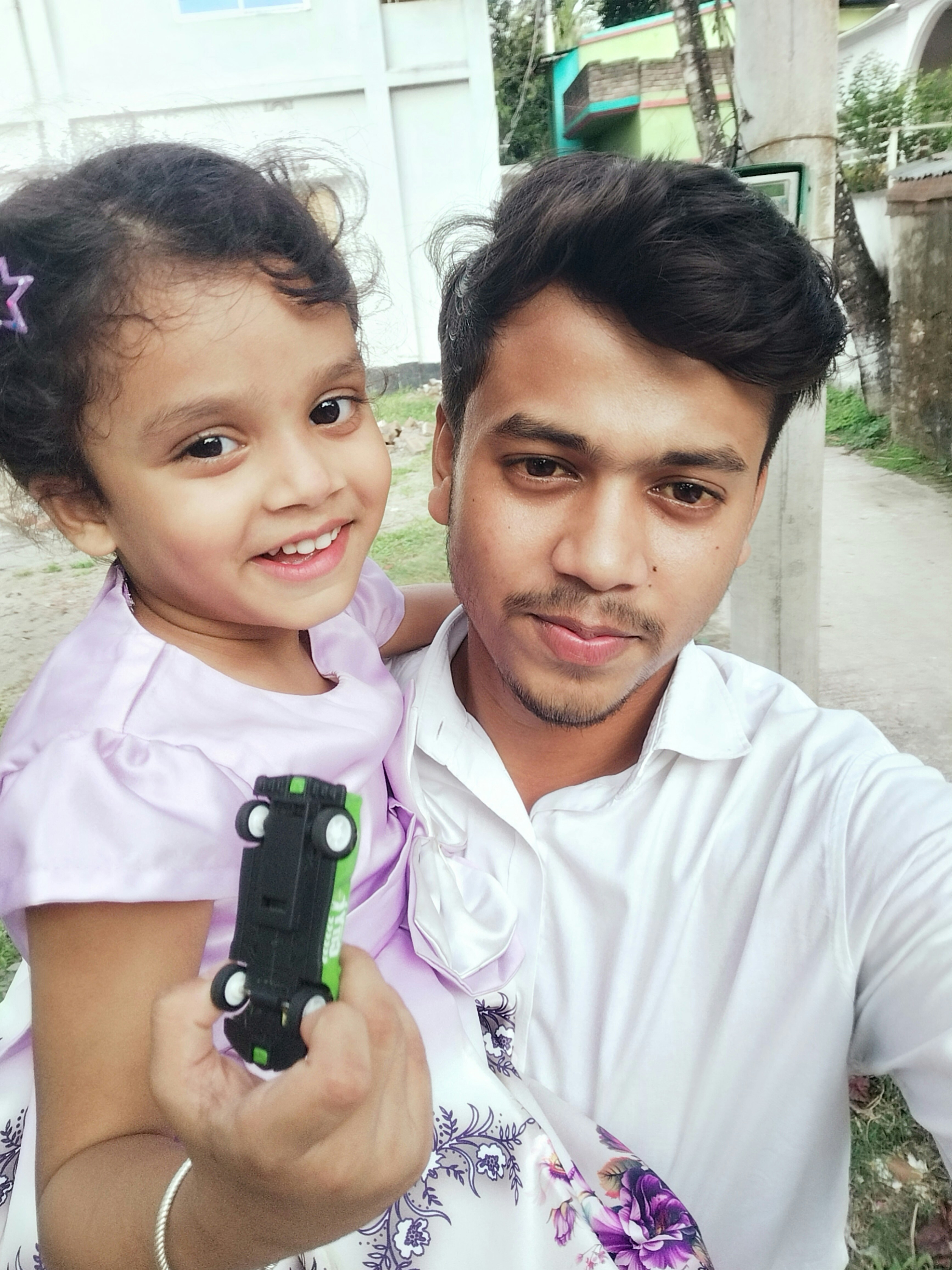 Selfie with a toy car: a warm moment captured outdoors
