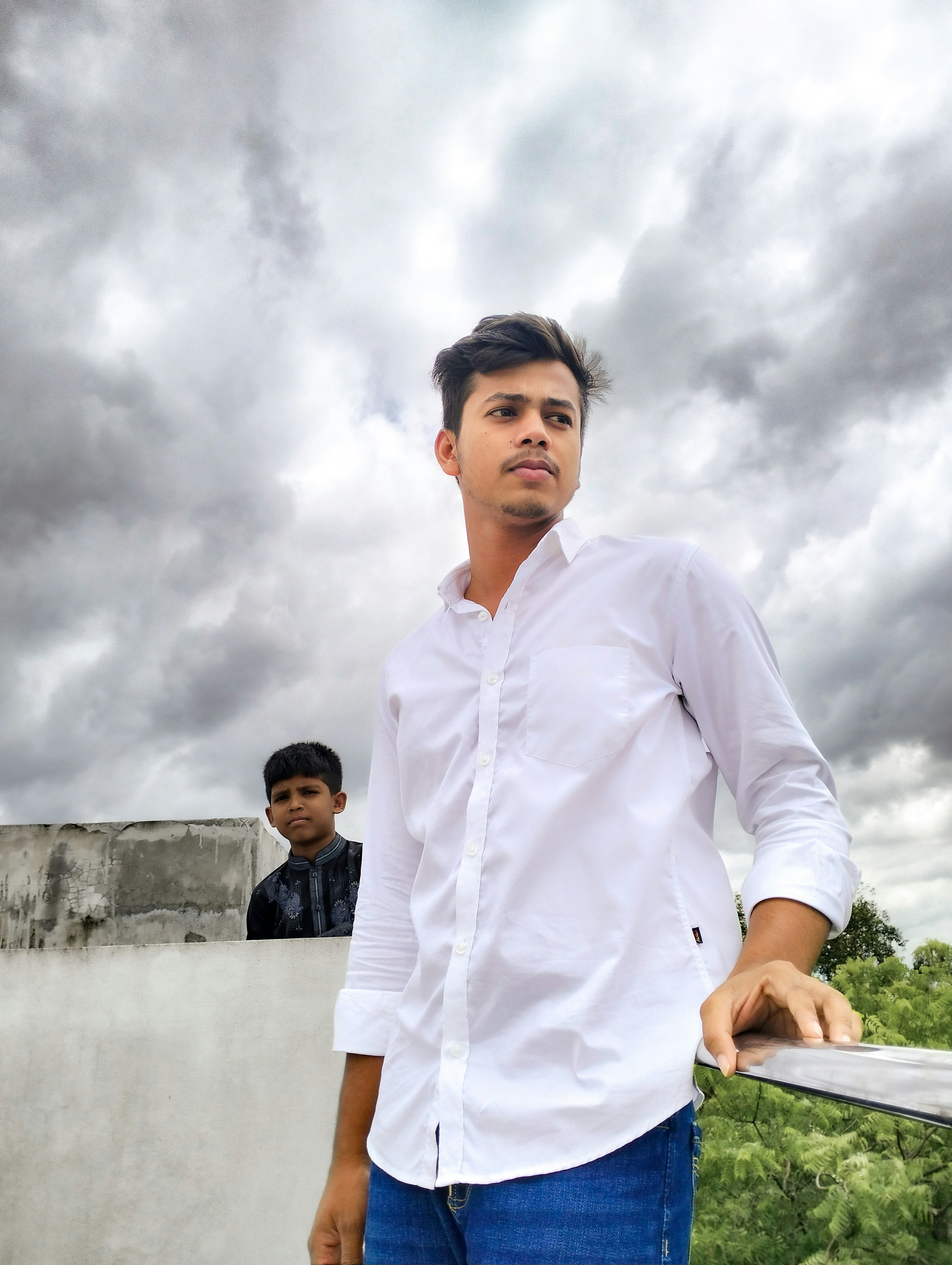 White-shirted lead on a rooftop against a dramatic cloudscape