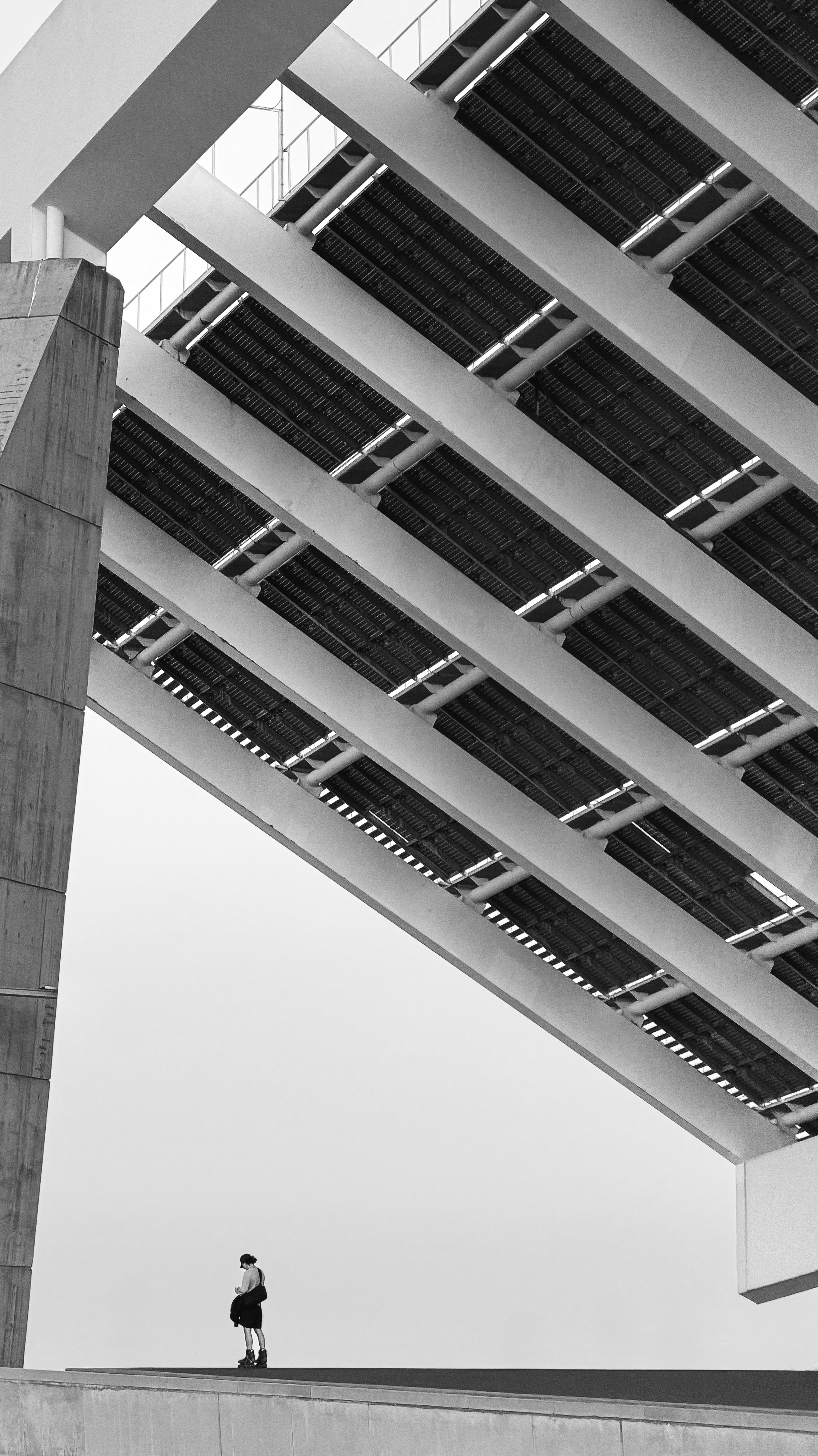  lone figure beneath a canyon of beams