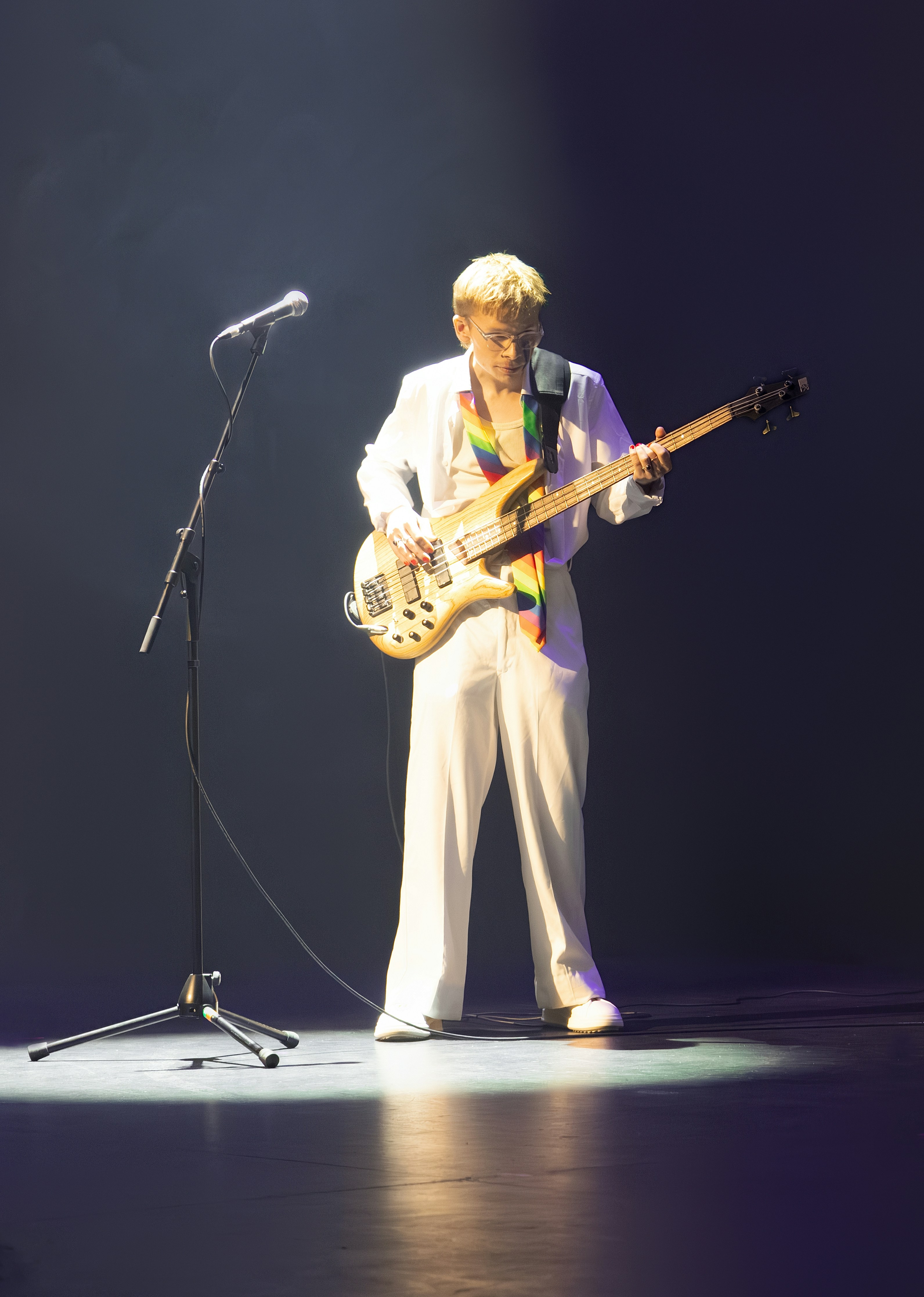 Stage Light Sonata: A White-Suited Bassist Under Solo Spotlight