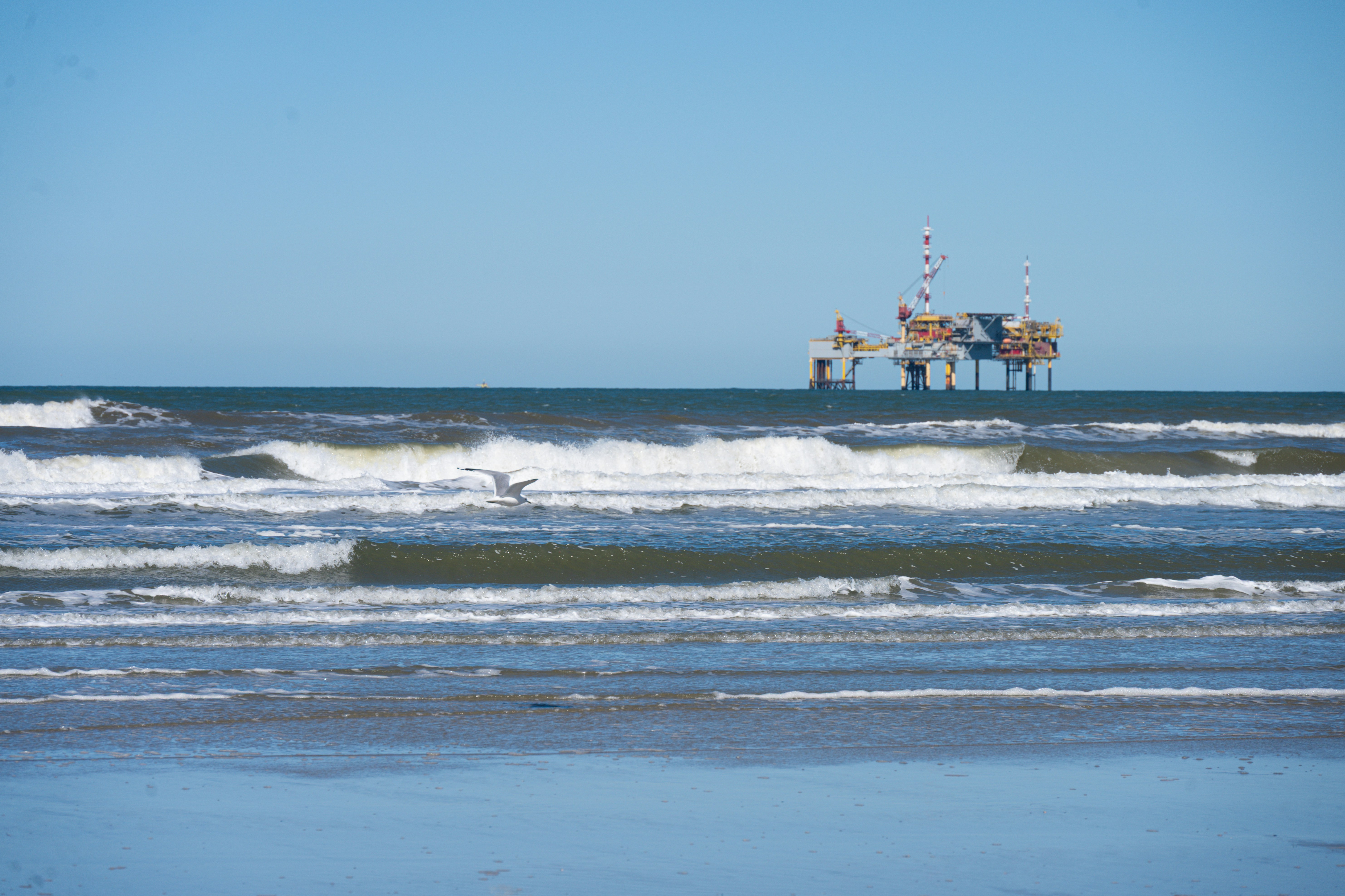 Ocean's Edge Pier: Waves, Light, and a Distant Platform