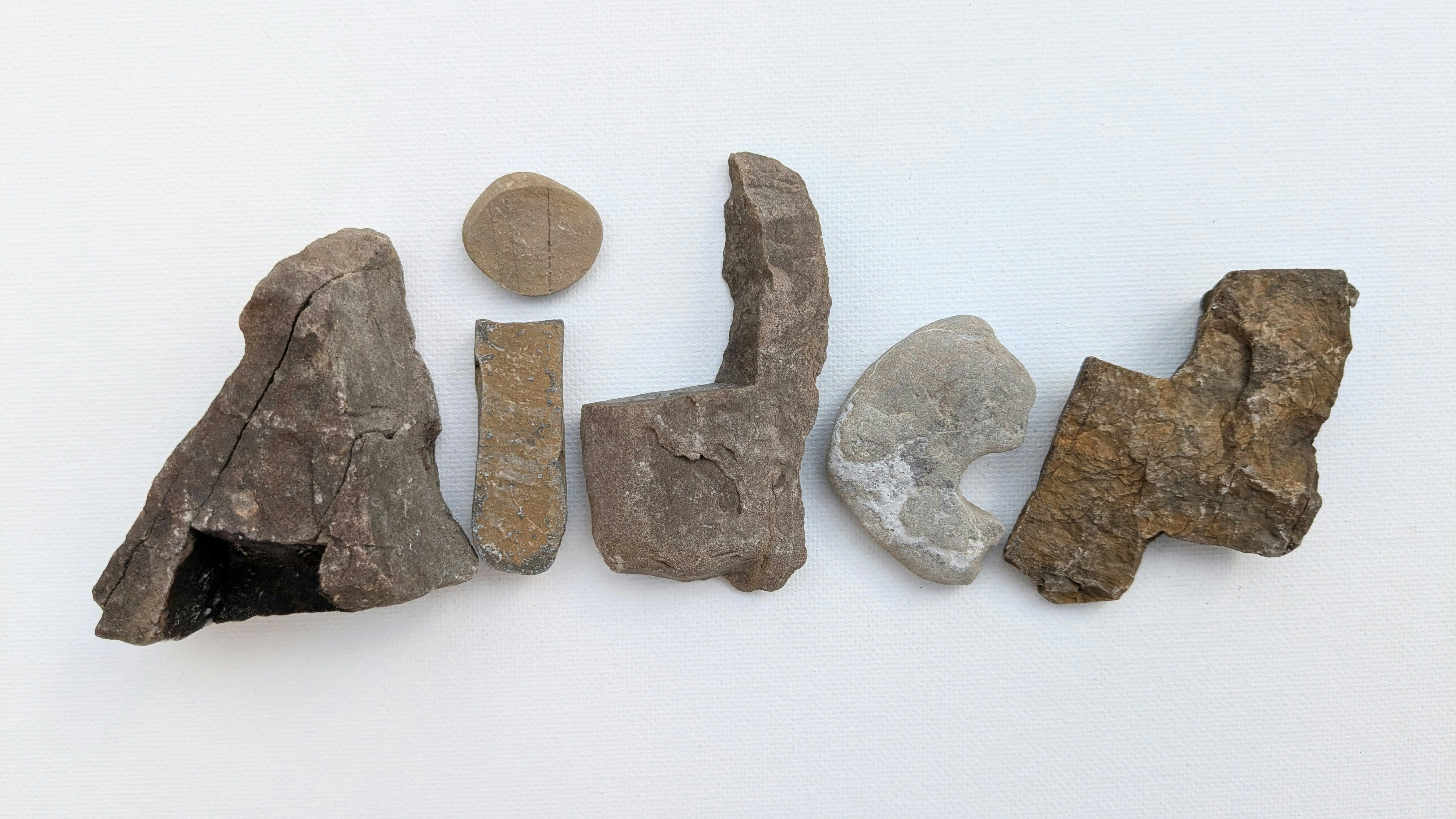 Rubble Letters Forming the Word 'AID' on a Minimal White Canvas