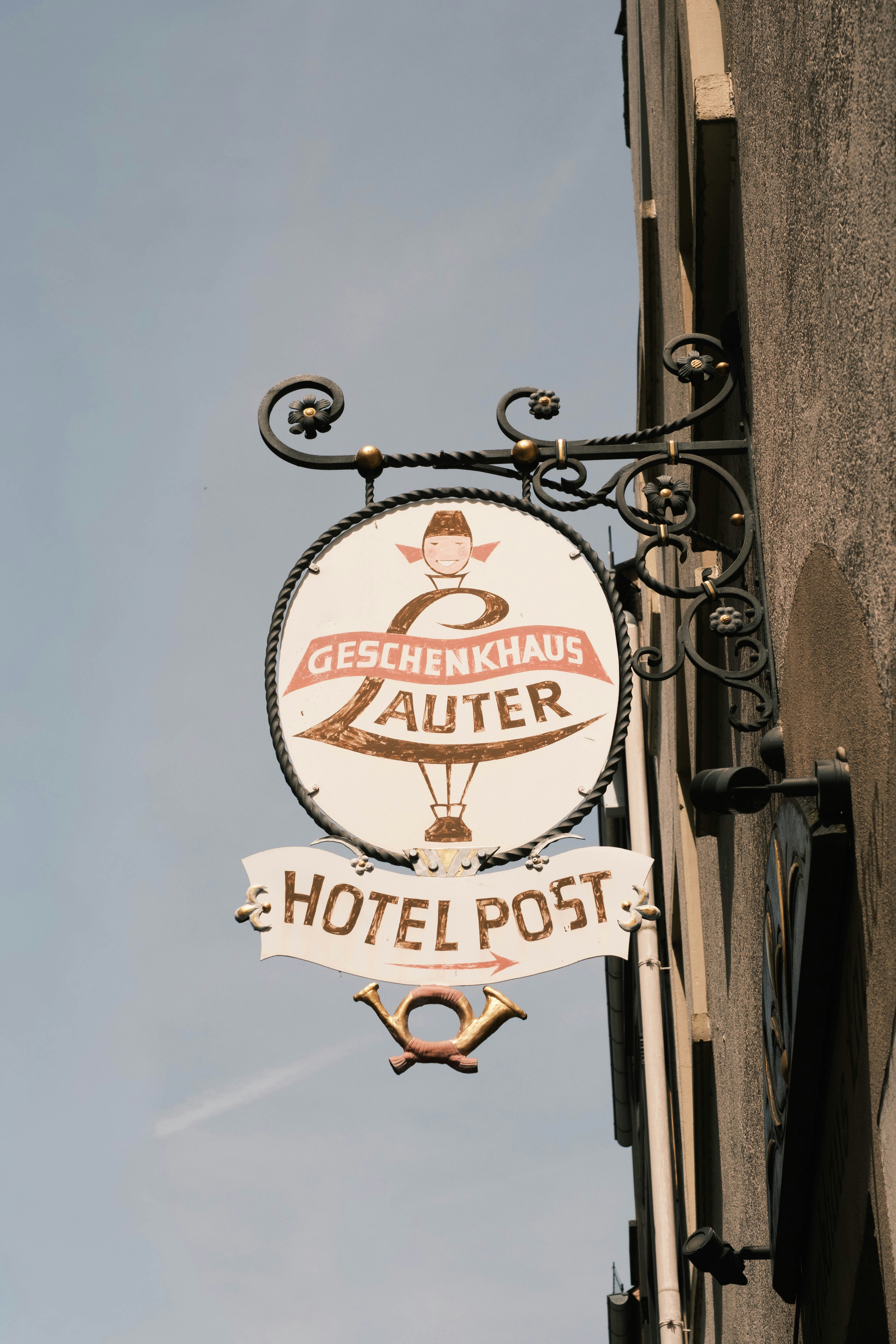 Signage in the Wind: A Vintage Hotel Sign Adorned with Curves and Ironwork