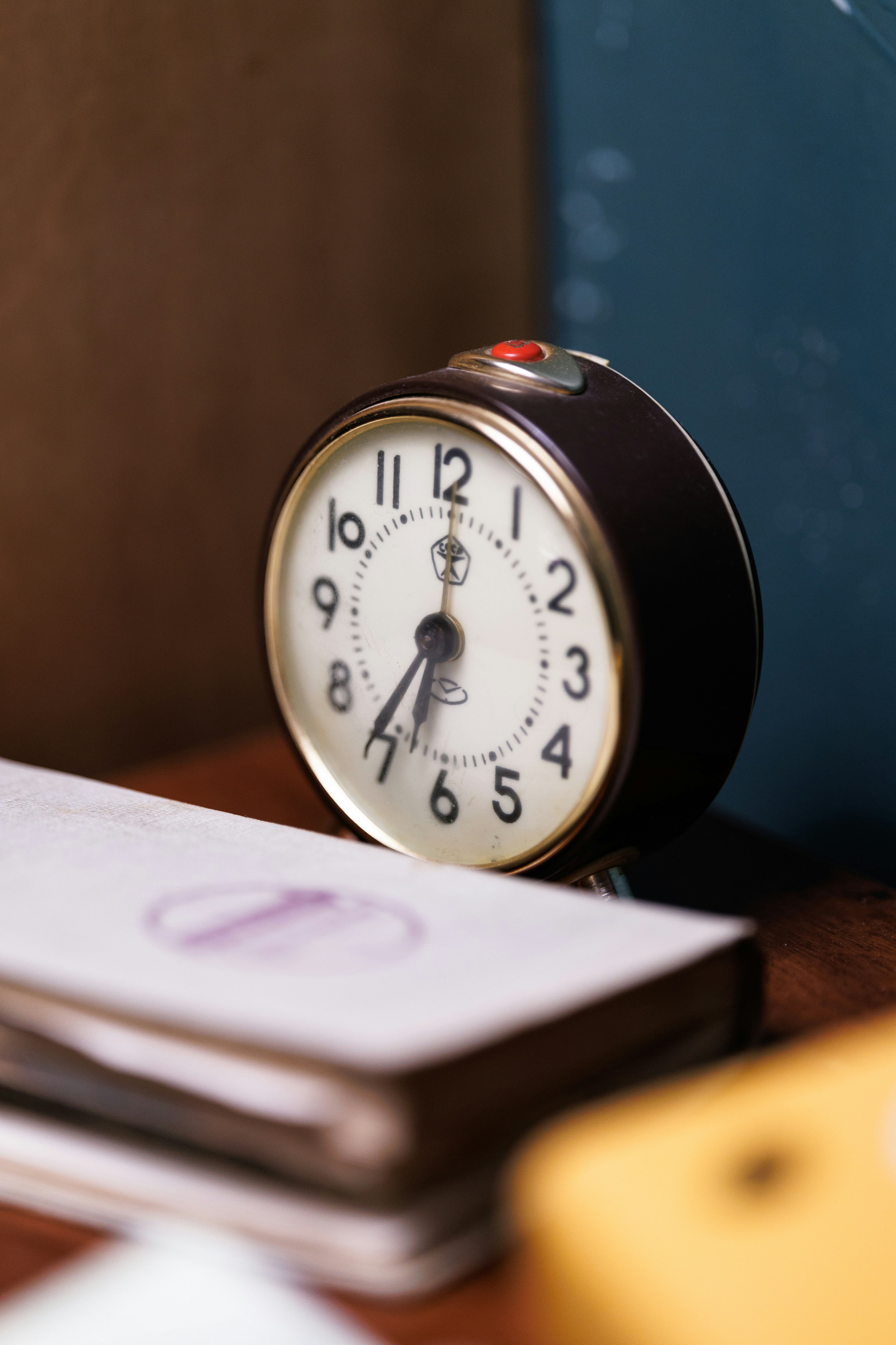 Timekeeper in Focus: A Quiet Morning Clocklet resting beside a stack of papers