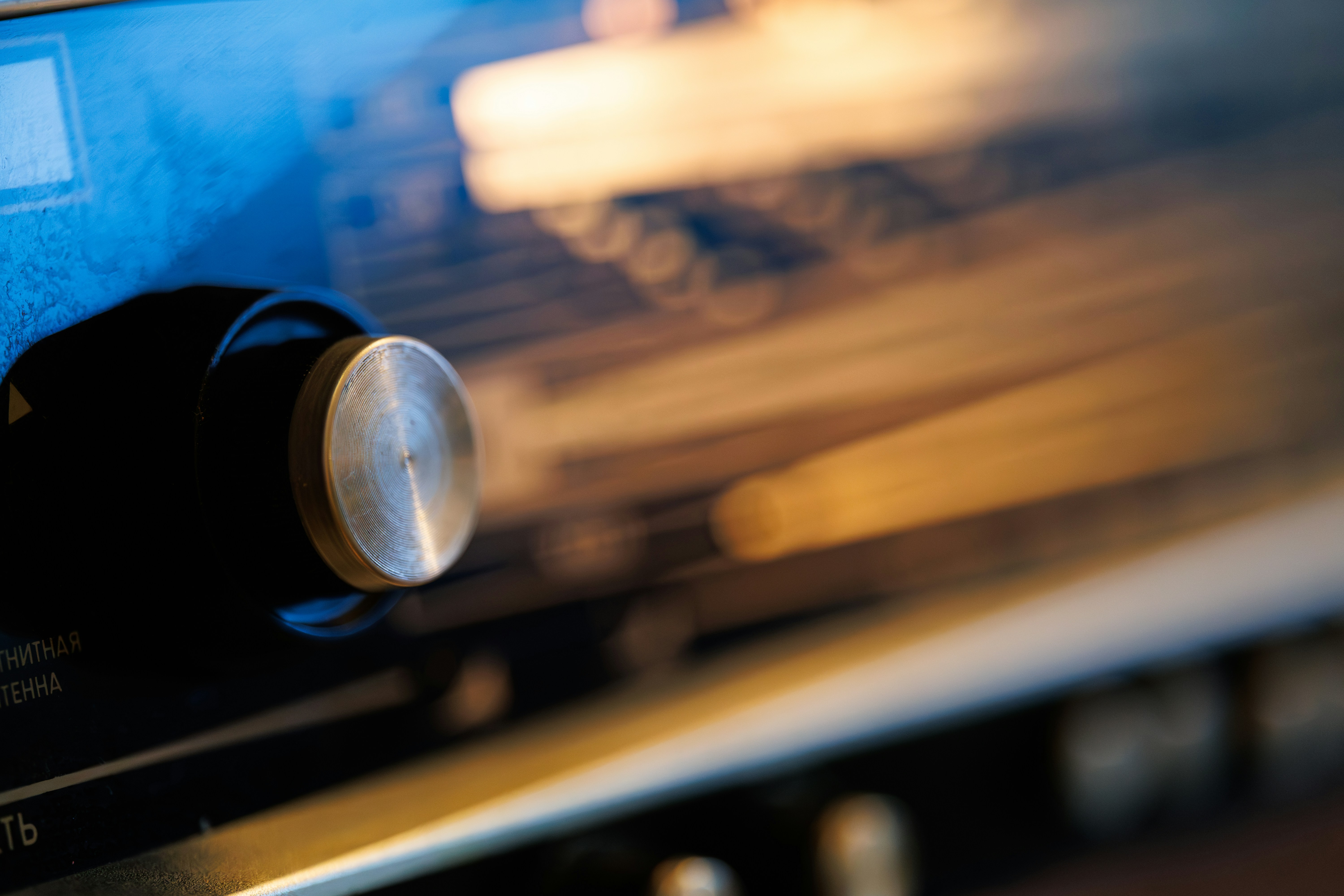 Close-up of a retro car radio knob bathed in moody blue-gold light