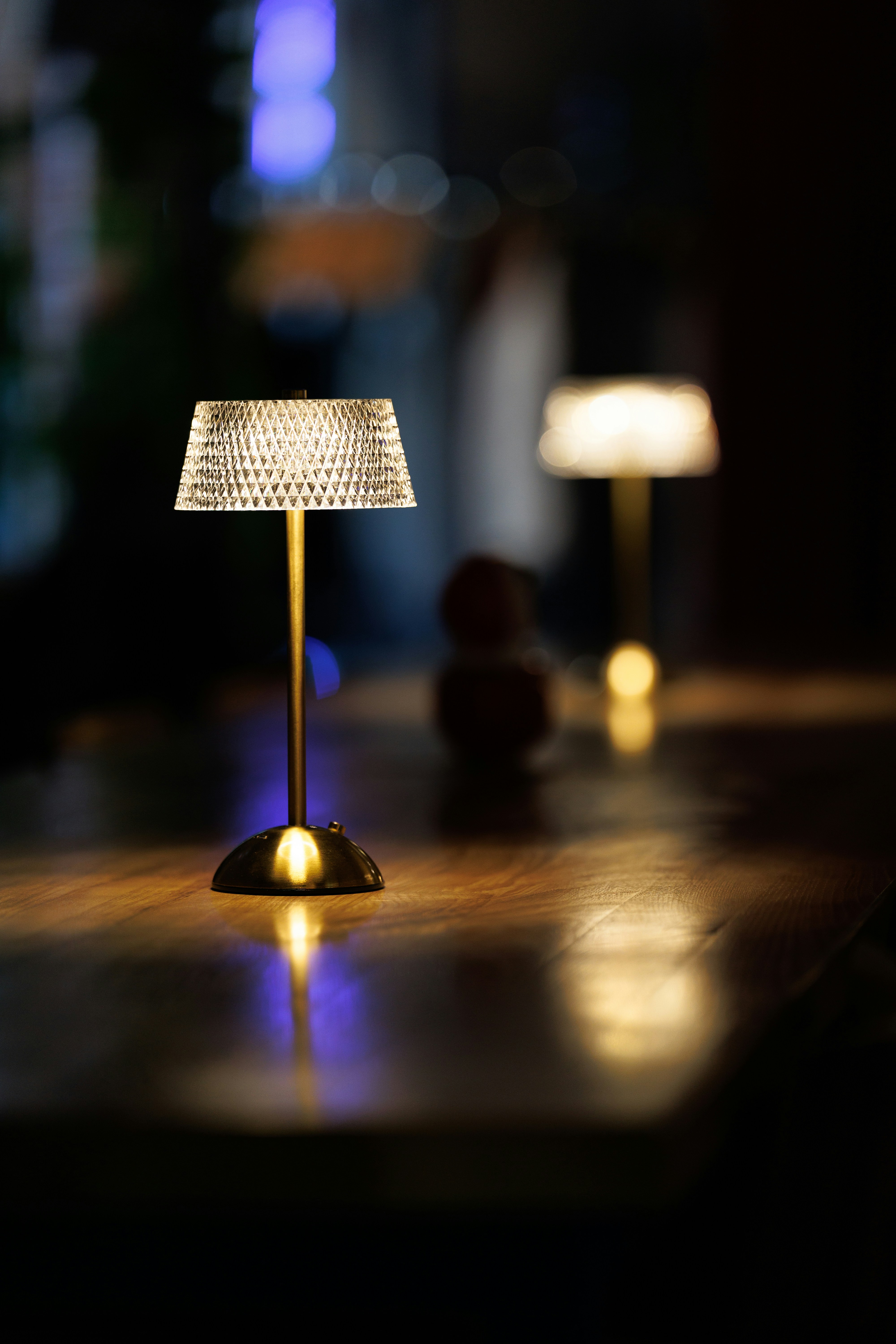 Warm Glow: A Table Lamp in Focus on a Quiet Bar