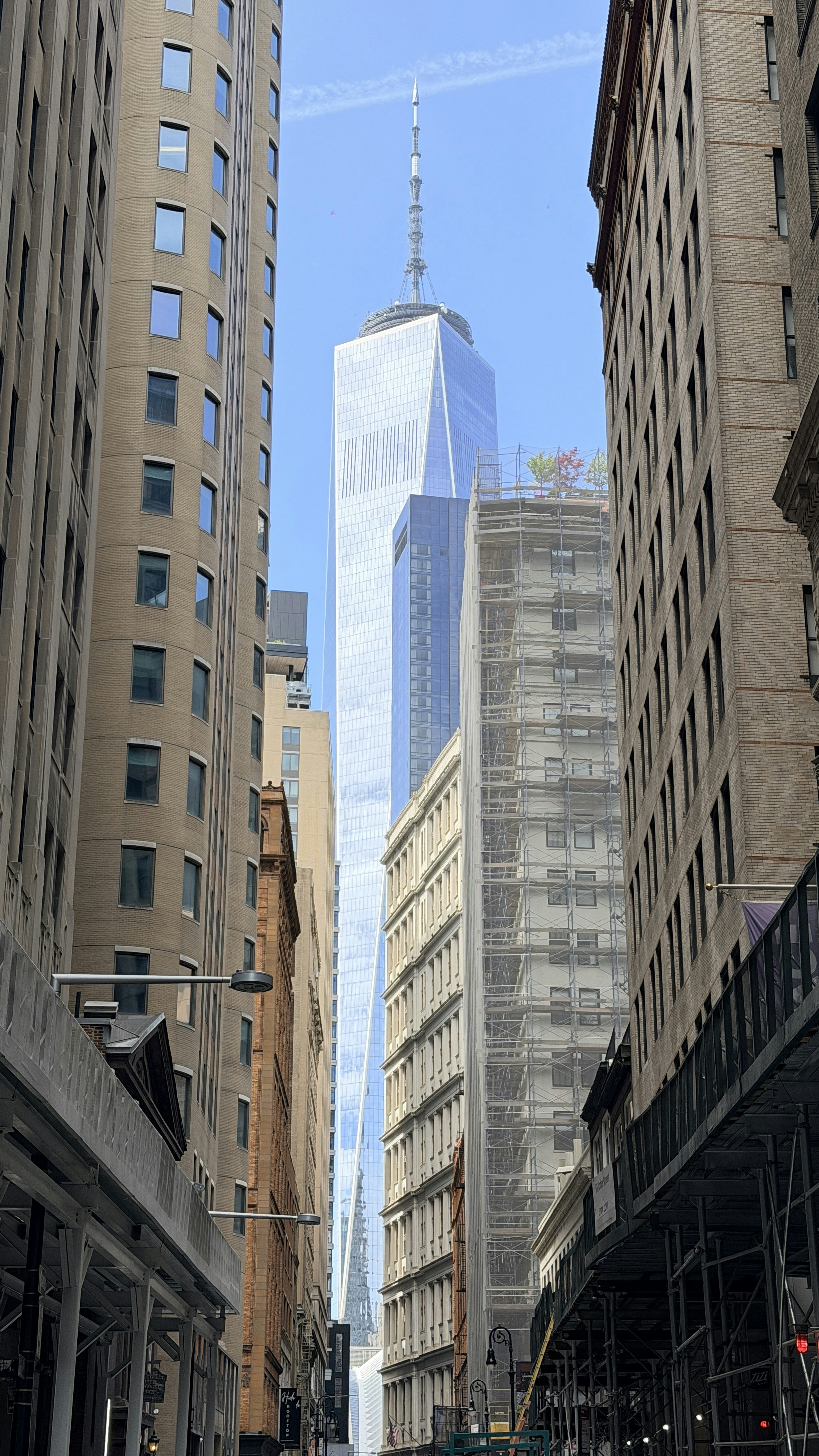 Skyward Needle: One World Tower Rising Between Narrow City Arches
