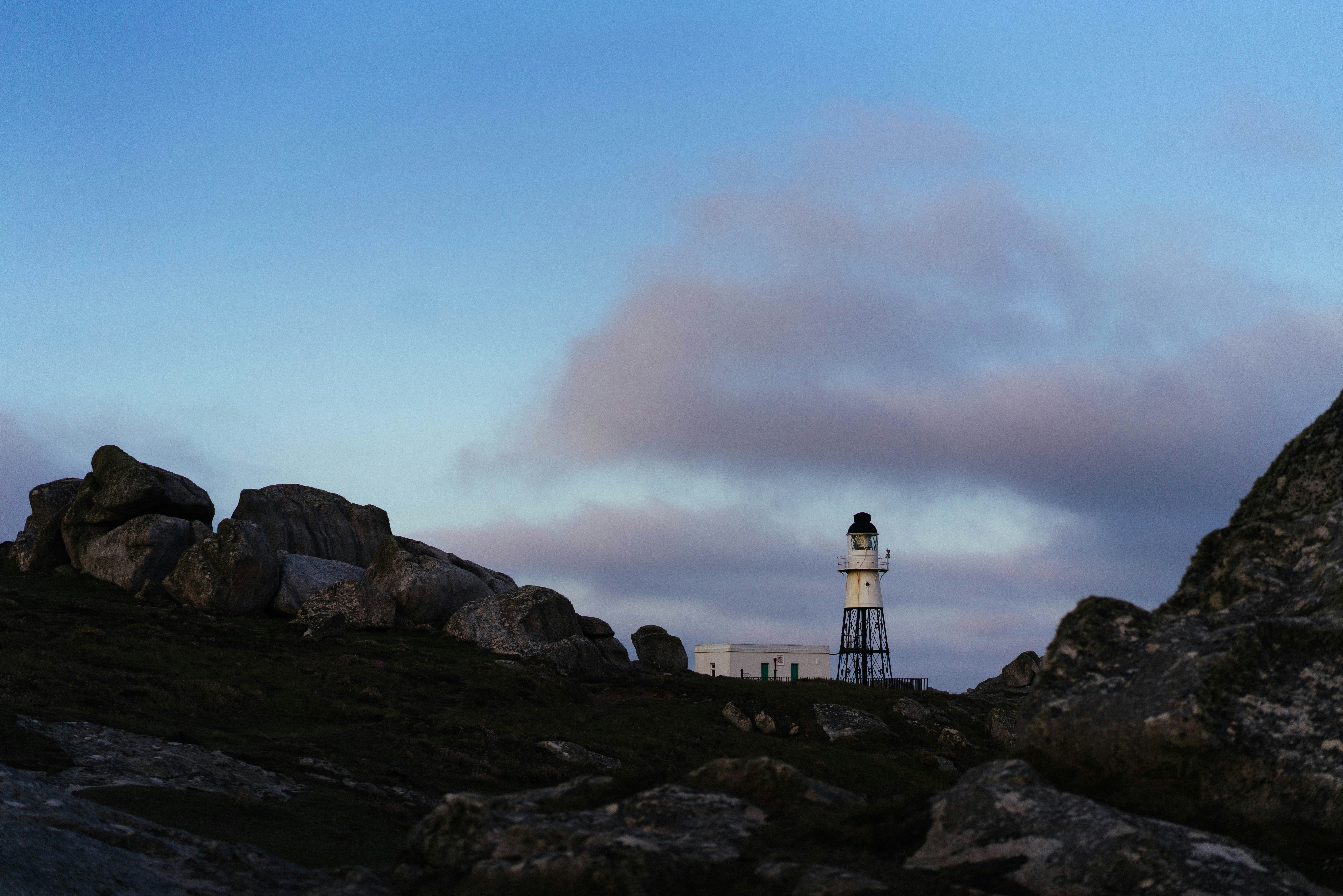 Lighthouse Veil: A Distant Beacon Among Coastal Tors