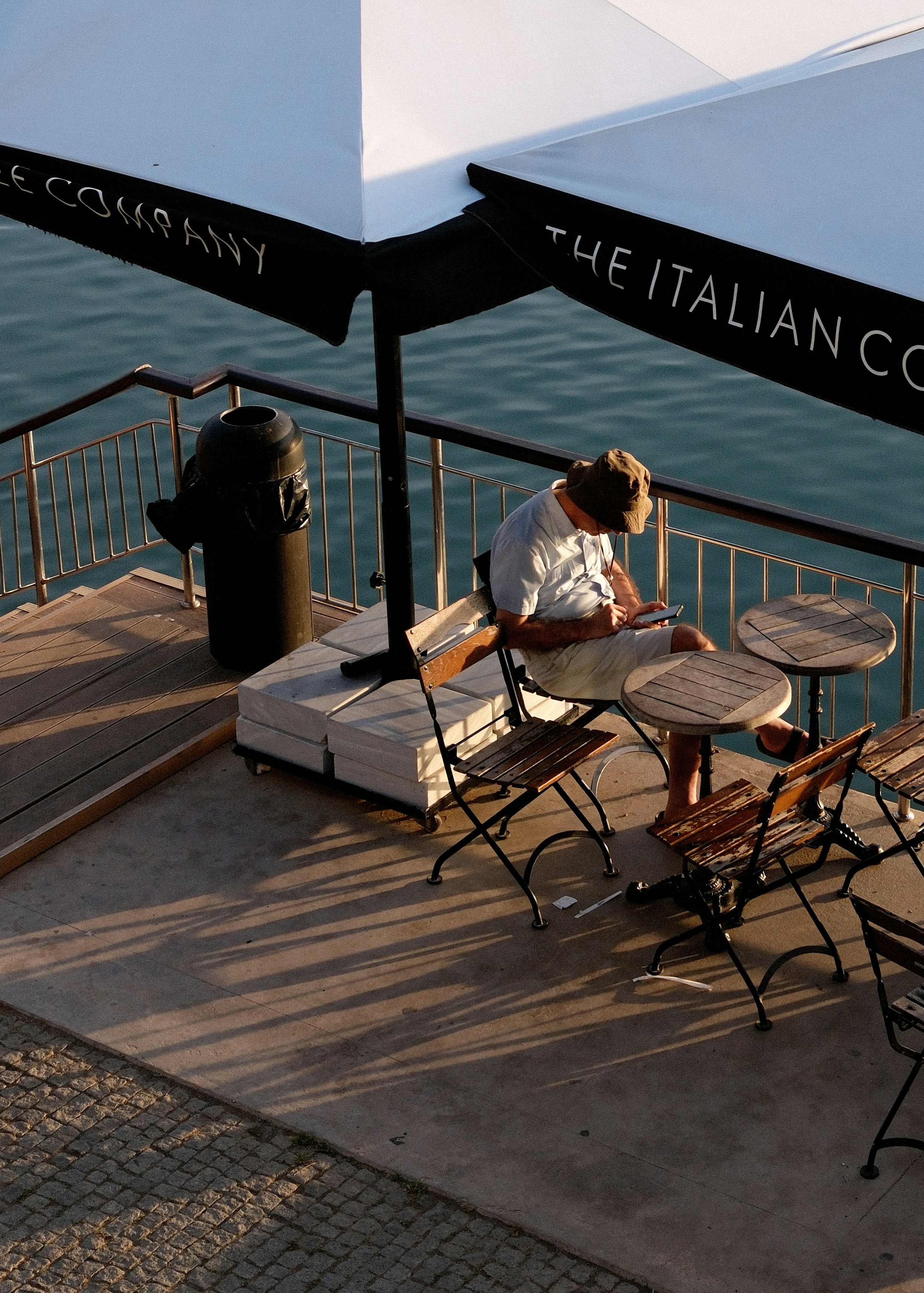 Shaded Café Corner: A Solo Moment Under the Italian Umbrella