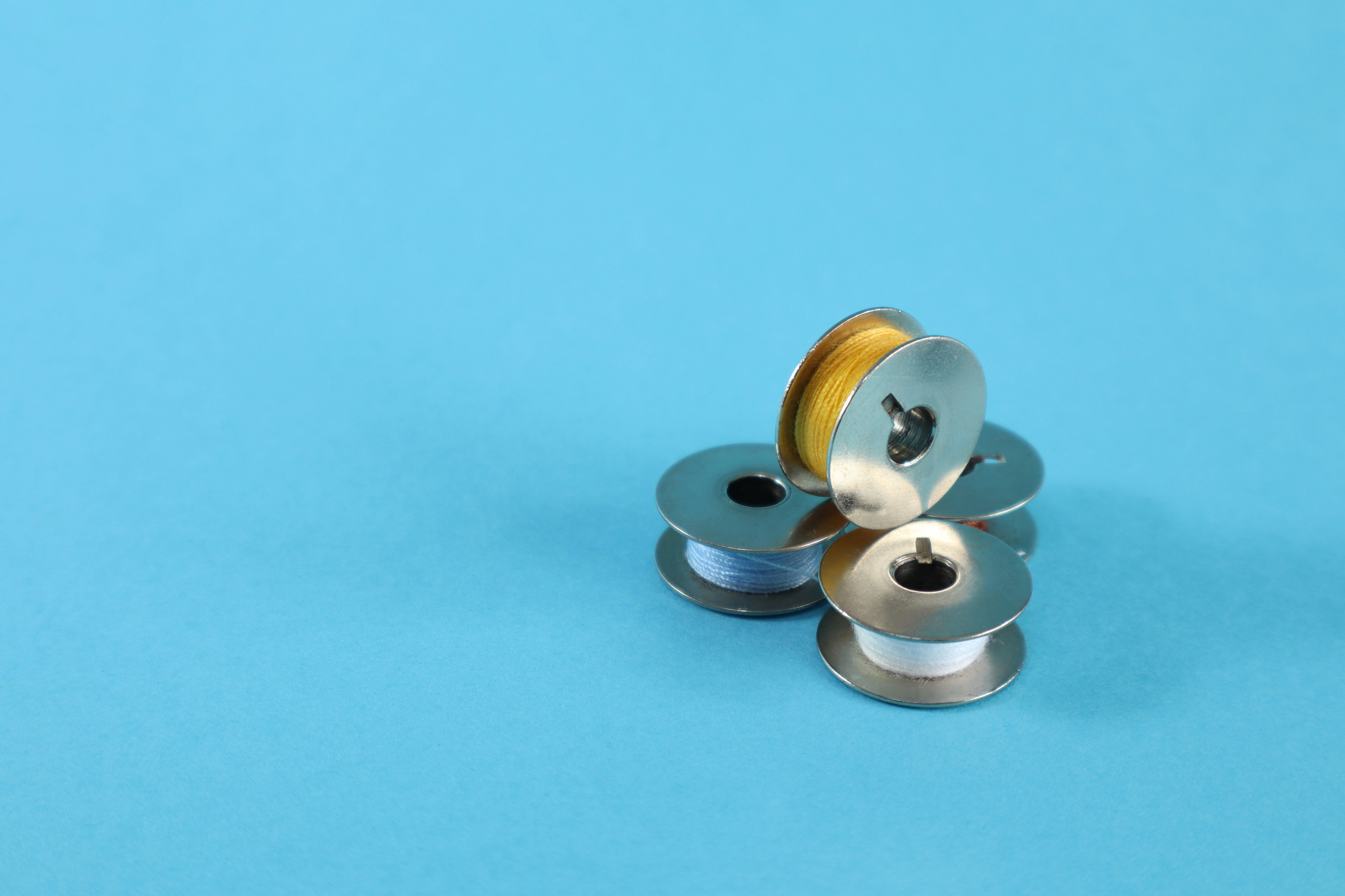 Spools of Colorful Thread Resting on a Blue Backdrop