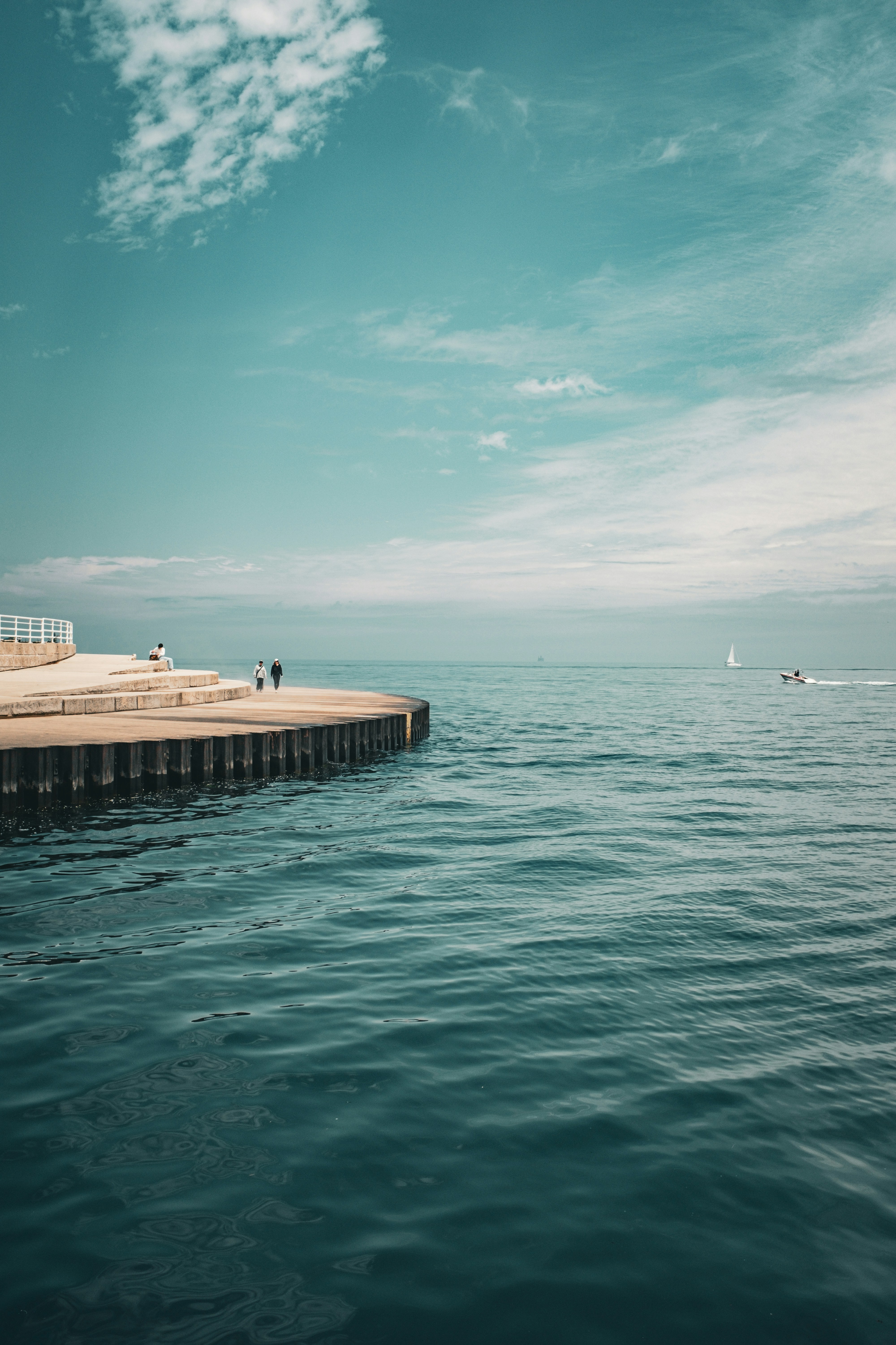 Sea Promenade at Dusk: A Quiet Curved Pier Extends into Calm Blue Waters