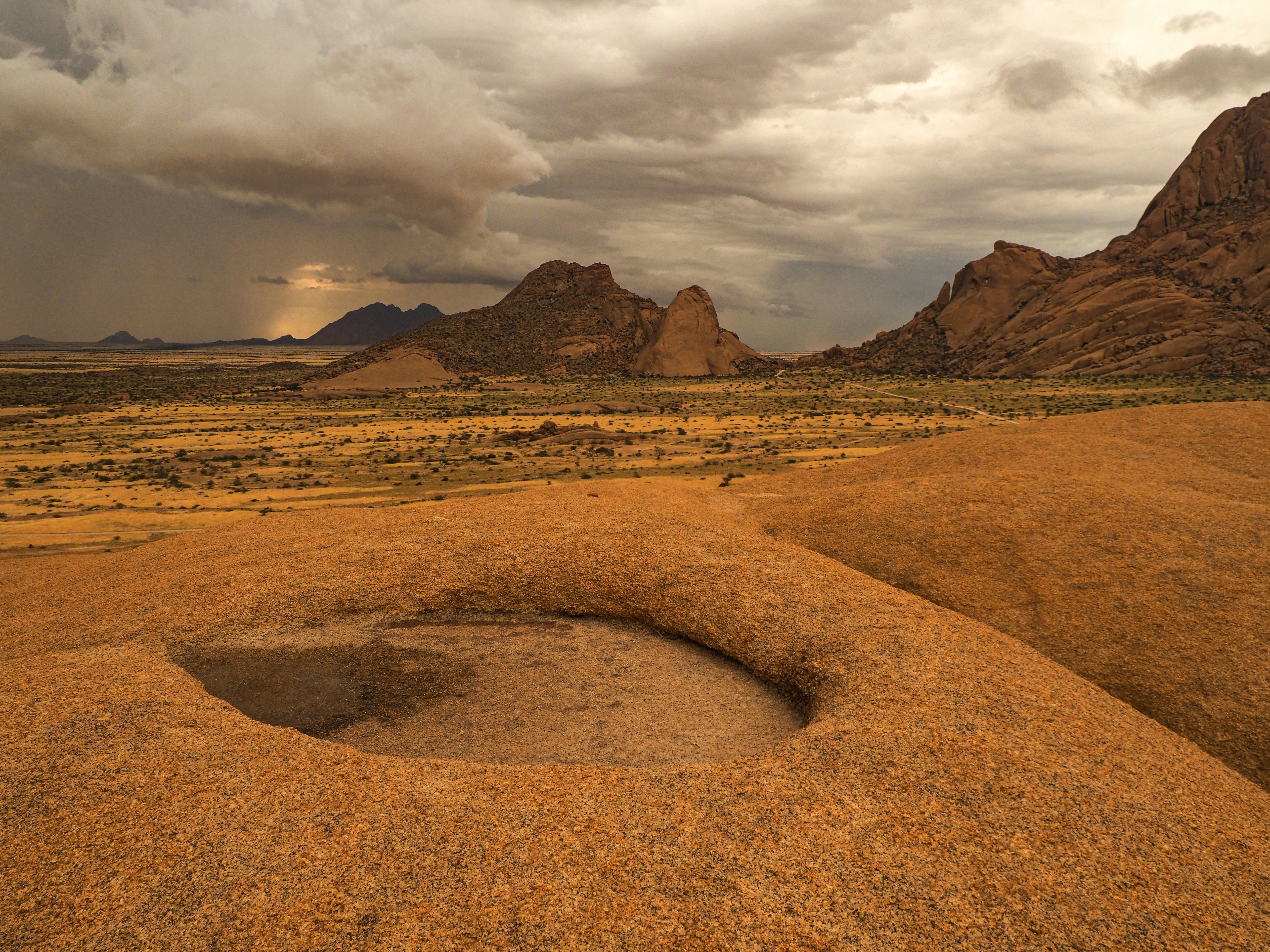 Desert Bassin: Circular Erosion Ring Against a Distant Range