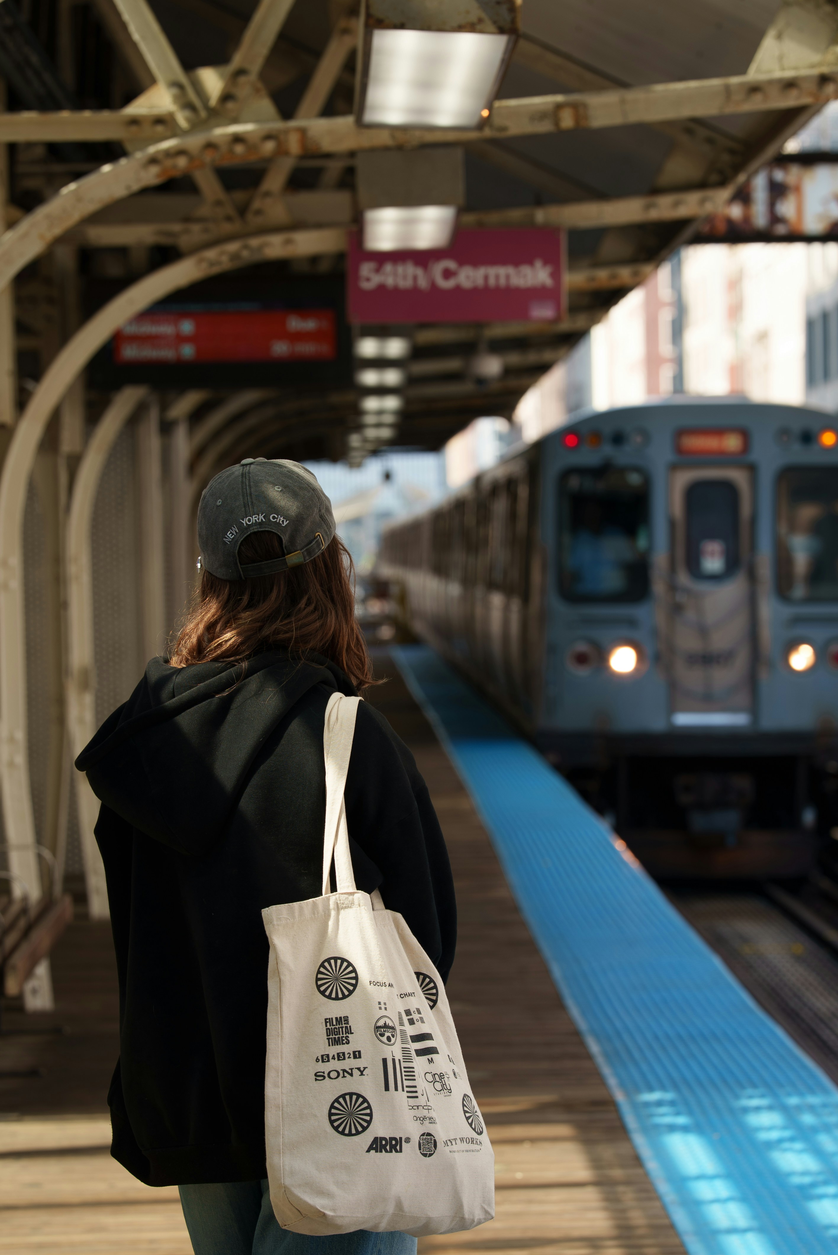 Platform Pause: A Woman with a Tote Faces the Arriving Train