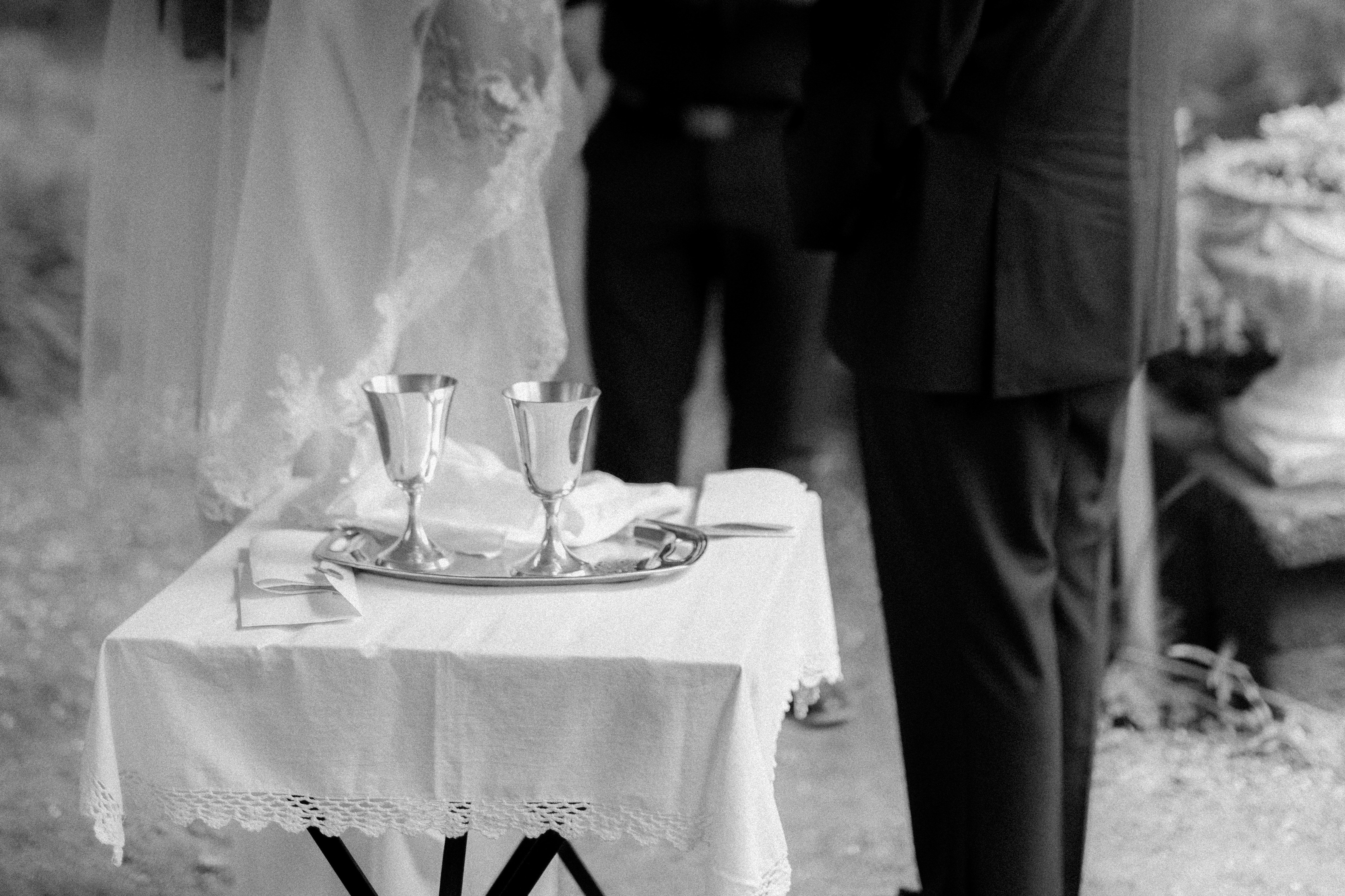 Two Glasses on a Lace-Draped Table Halt a Wedding Moment