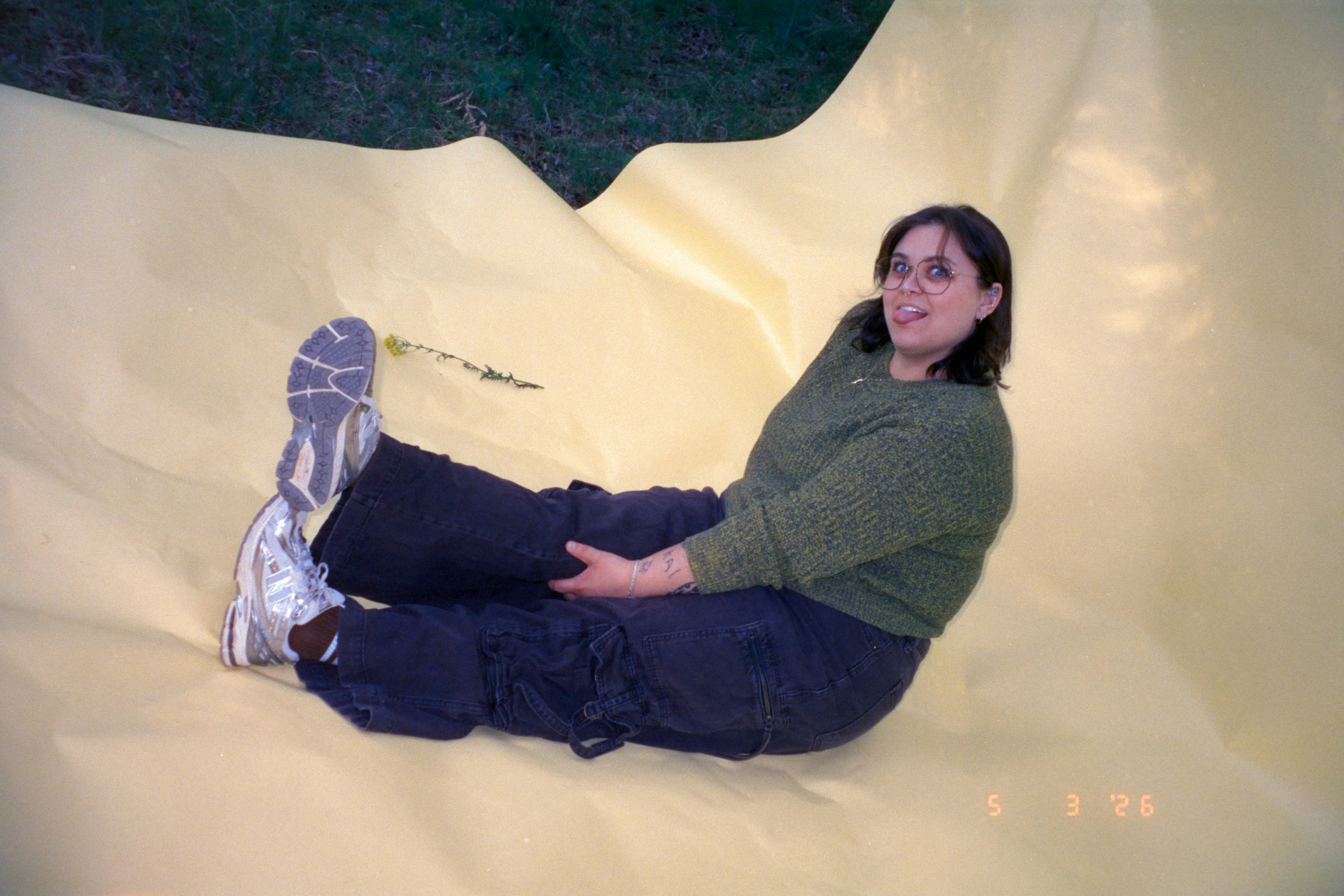 Smiling woman sitting on a large yellow inflatable structure.