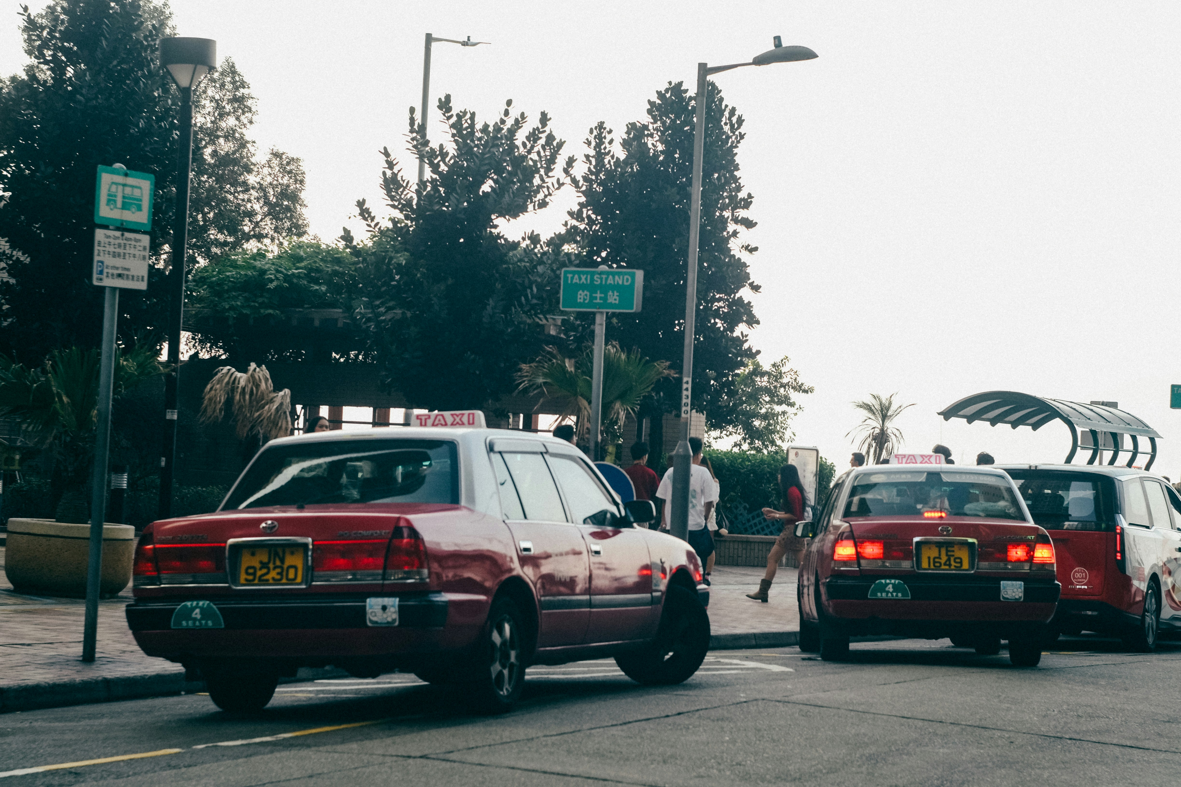 Urban taxi standoff at a sunlit curb