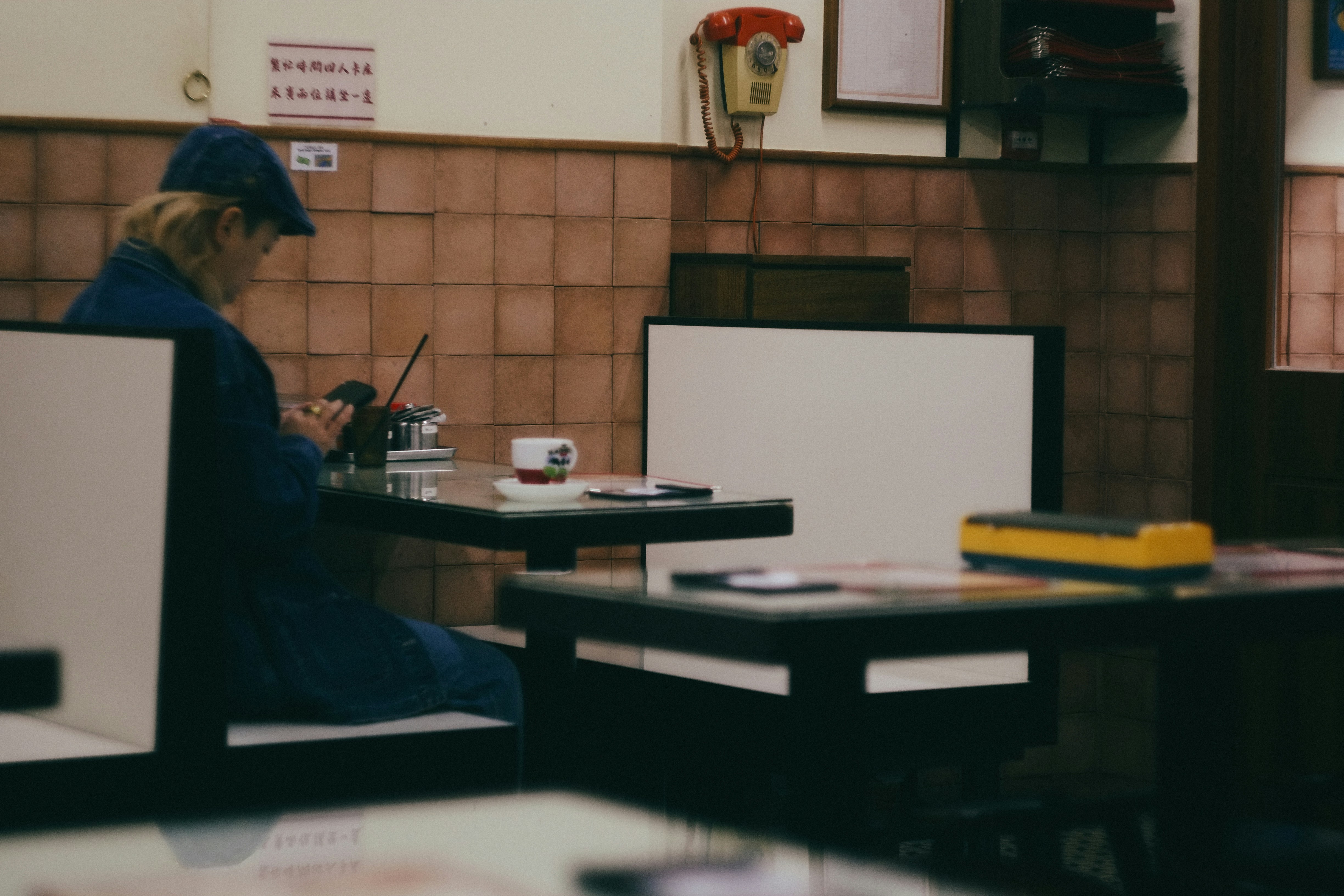 Quiet Worker: A Lone Figure in a Diner-like Space