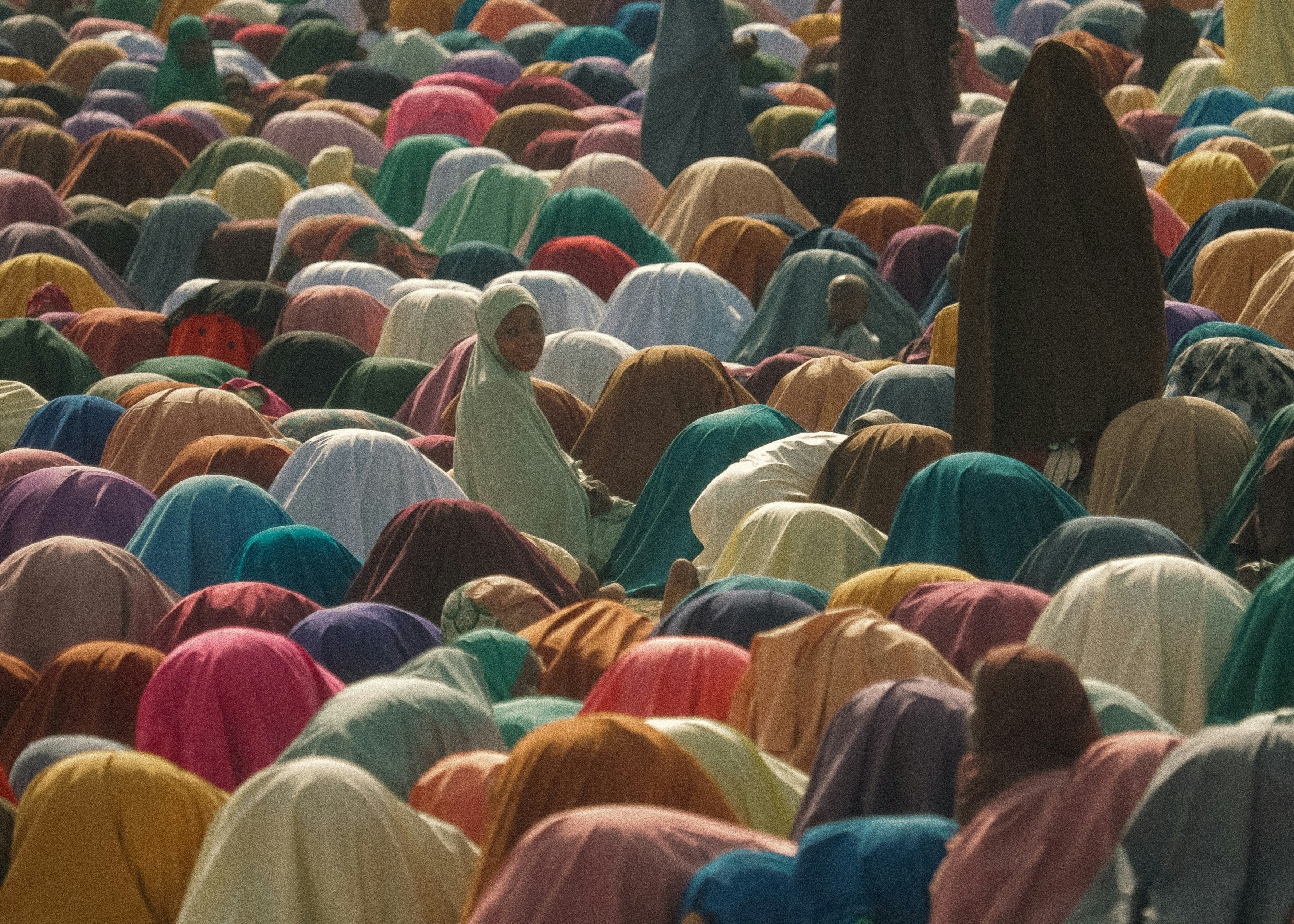 A Sea of Prayerful Hues: Women in Colorful Veils in a Distant Mosque Gathering