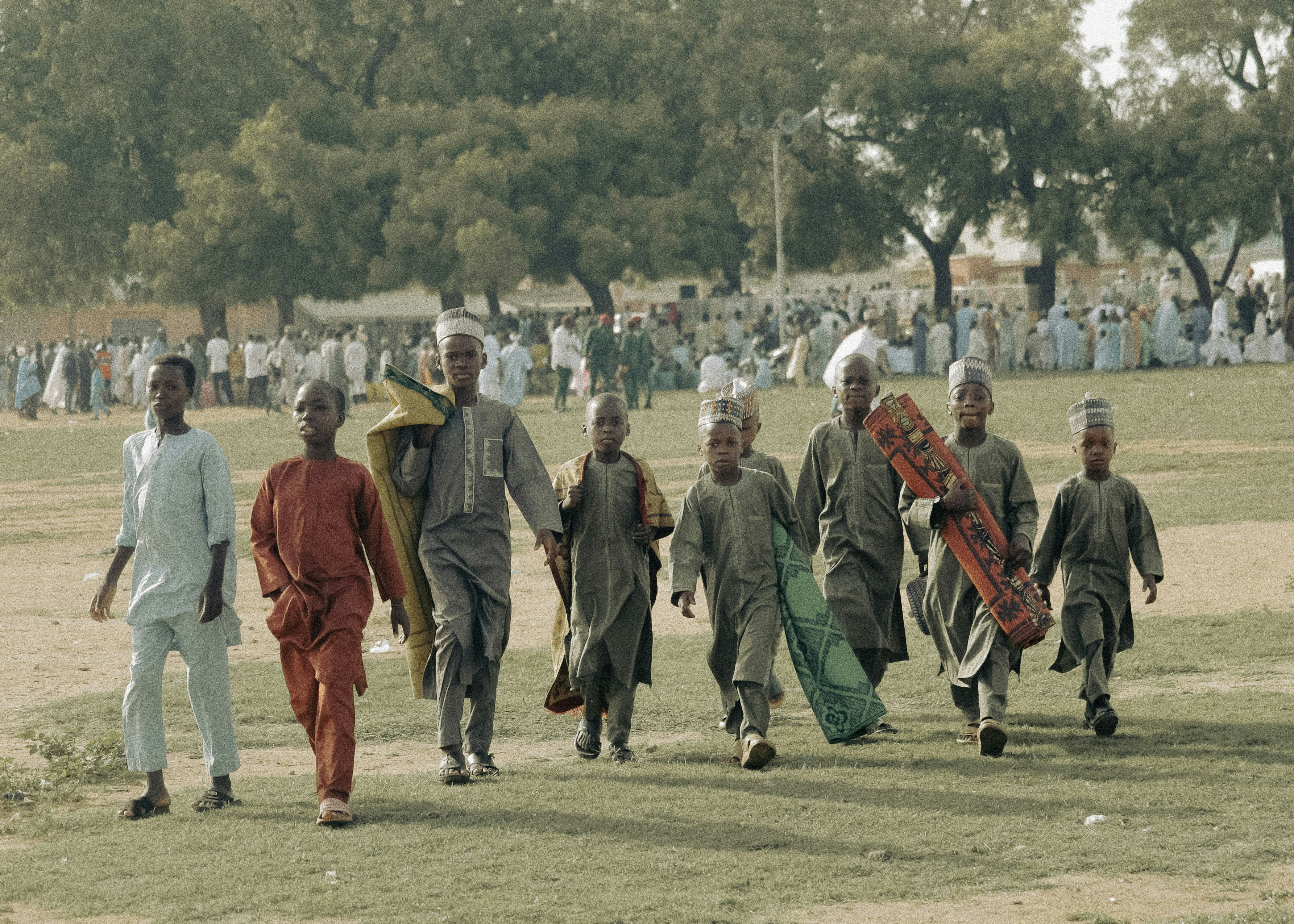 Procession of Cloth and Color Across a grassy Field