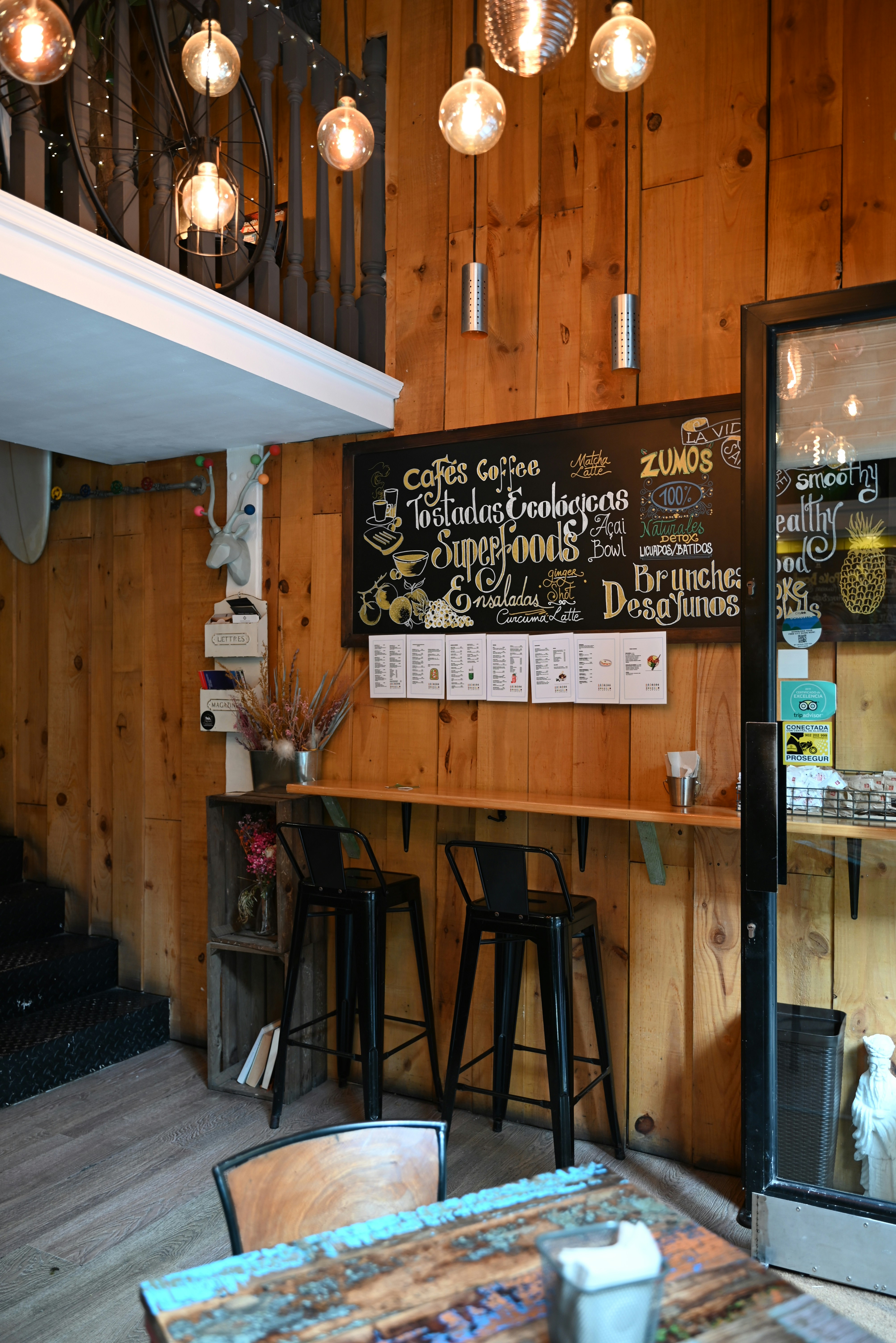 Warm Corner Café: Chalkboard Menu Under Hanging Bulbs