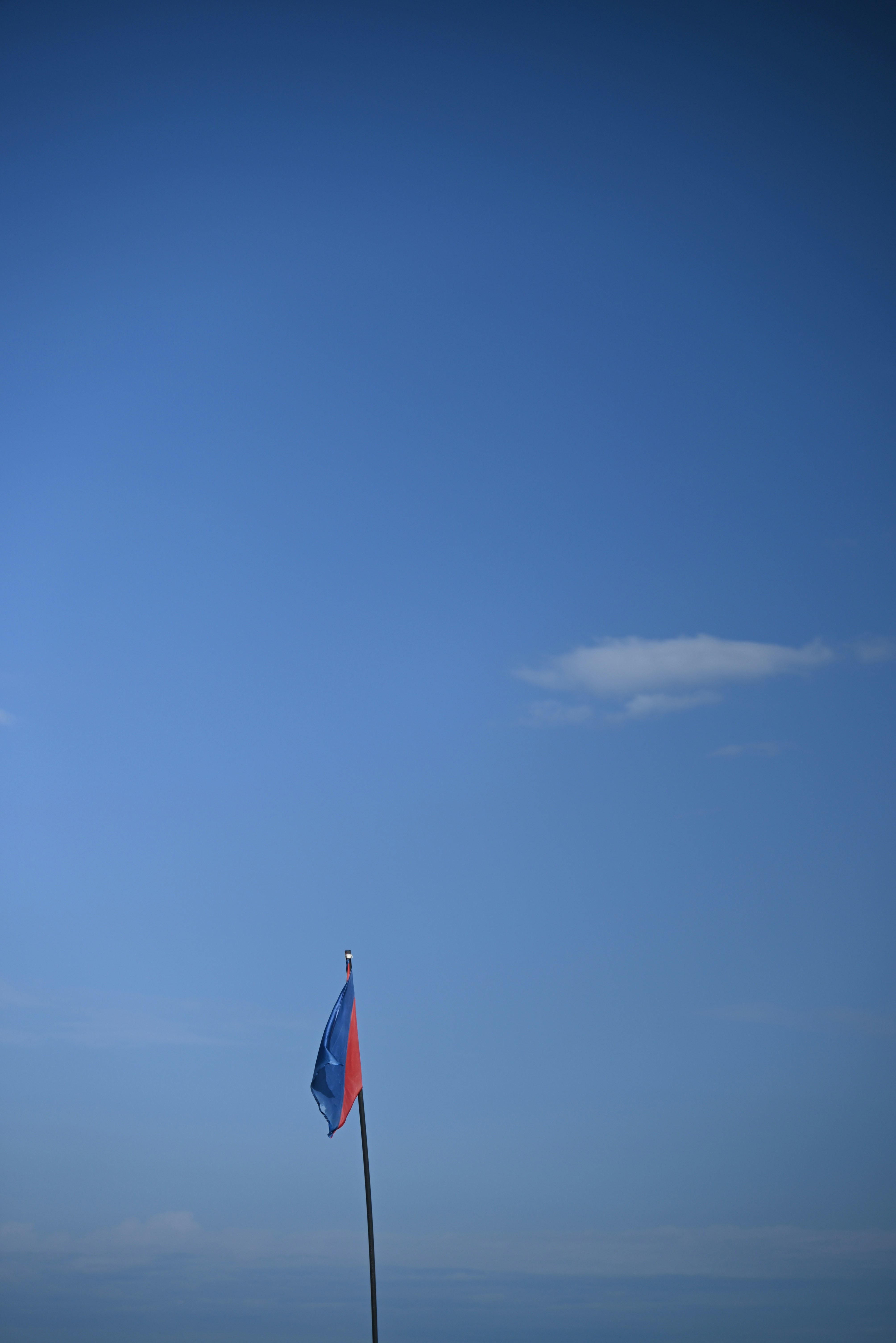 Flag Above the Horizon: A Quiet Vertical Sky Scene