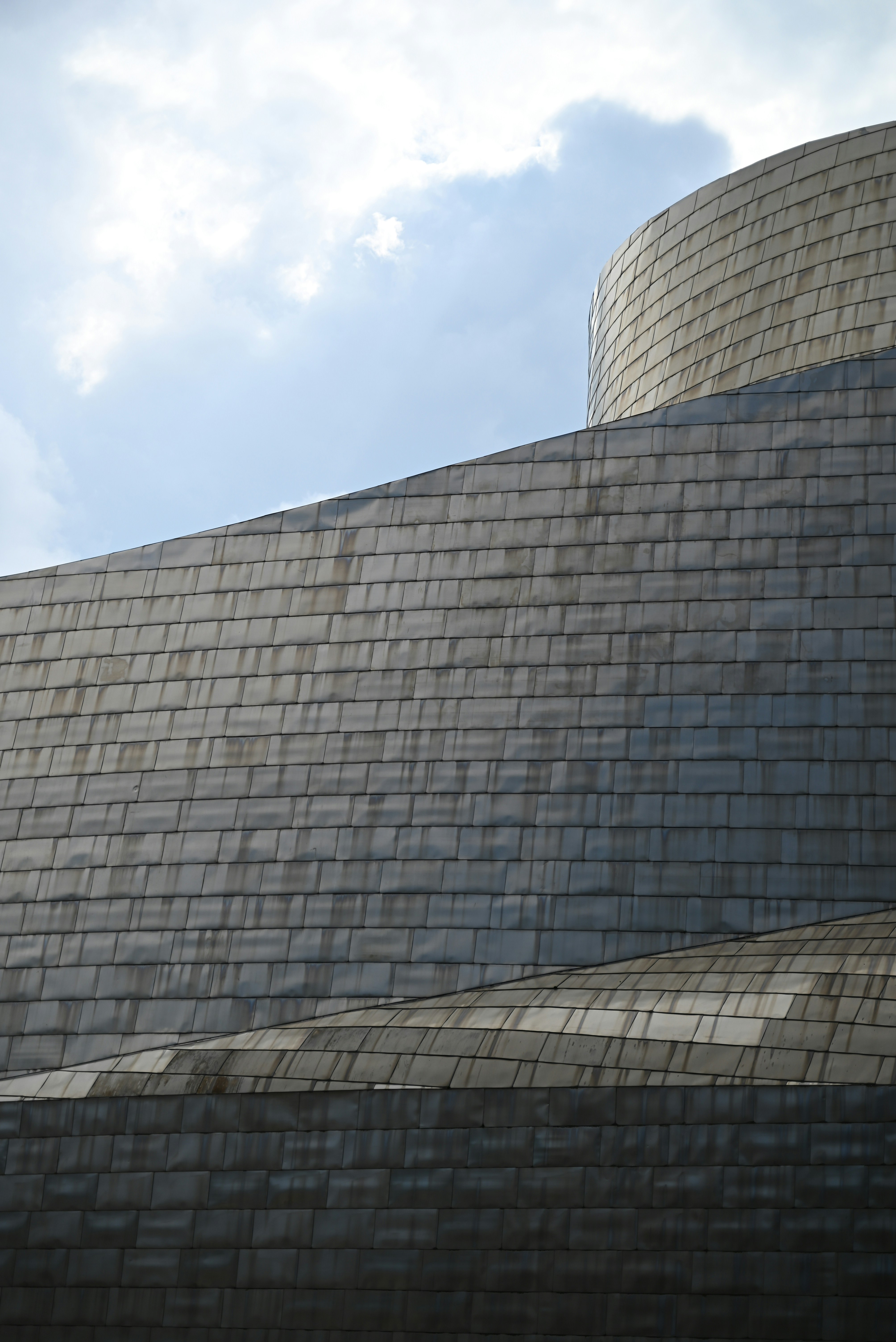 Architectural Curves: A Slate Tiled Facade Under Open Sky