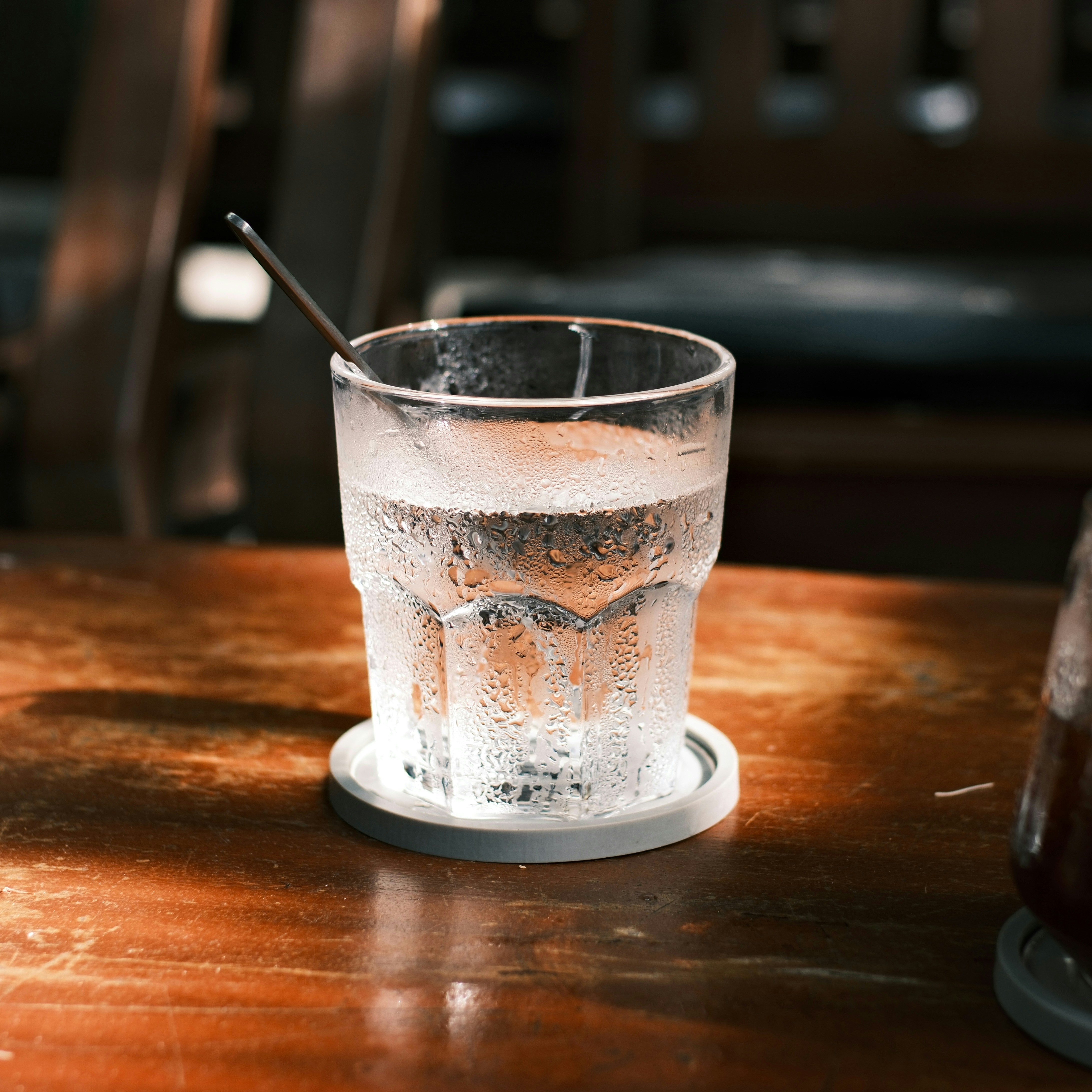 Chilled Clarity: A Glimmering Glass Resting on a Warm Bar
