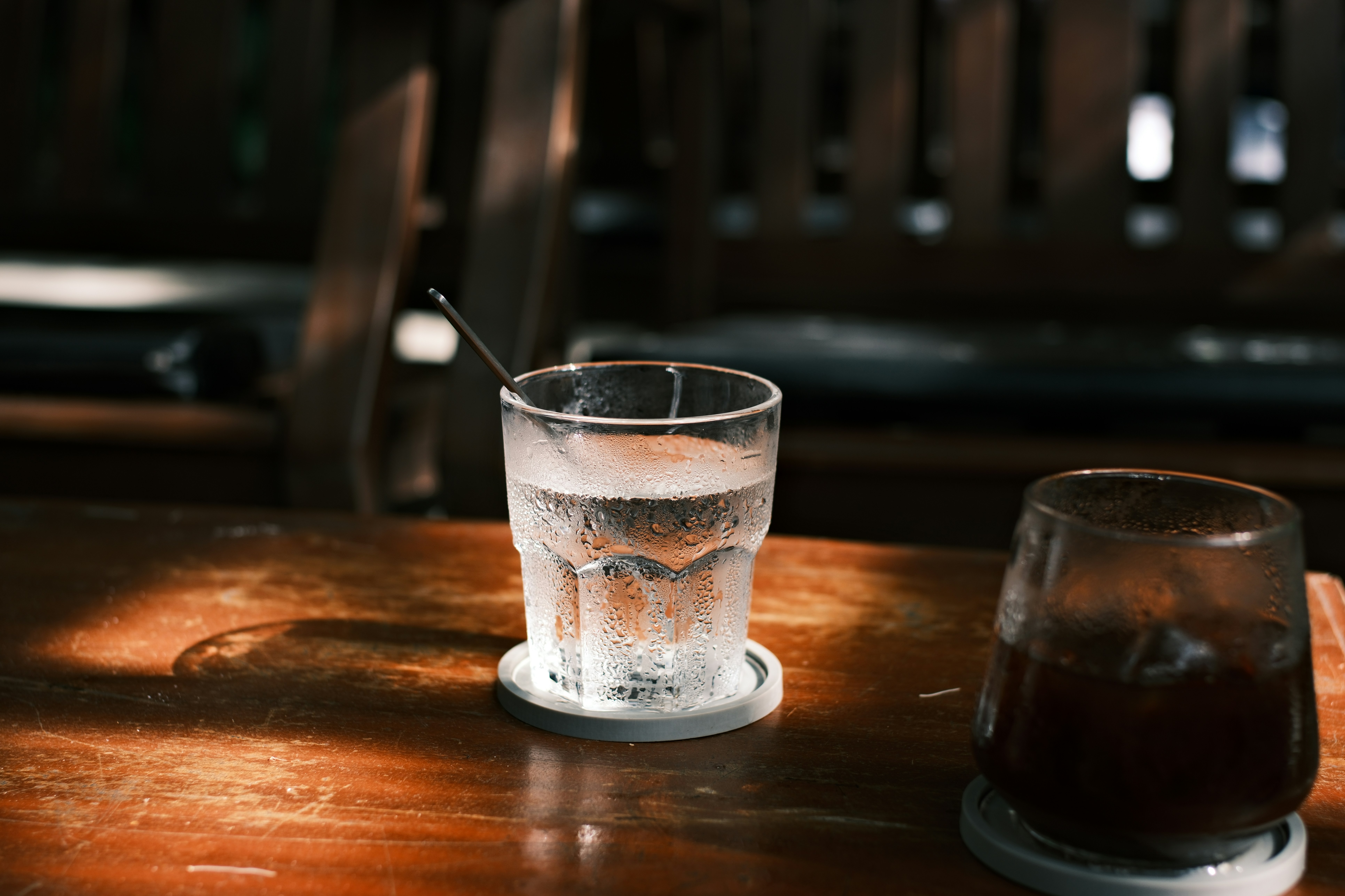 Glassy Moment: a Quiet Drink Illuminated on a Wooden Bar