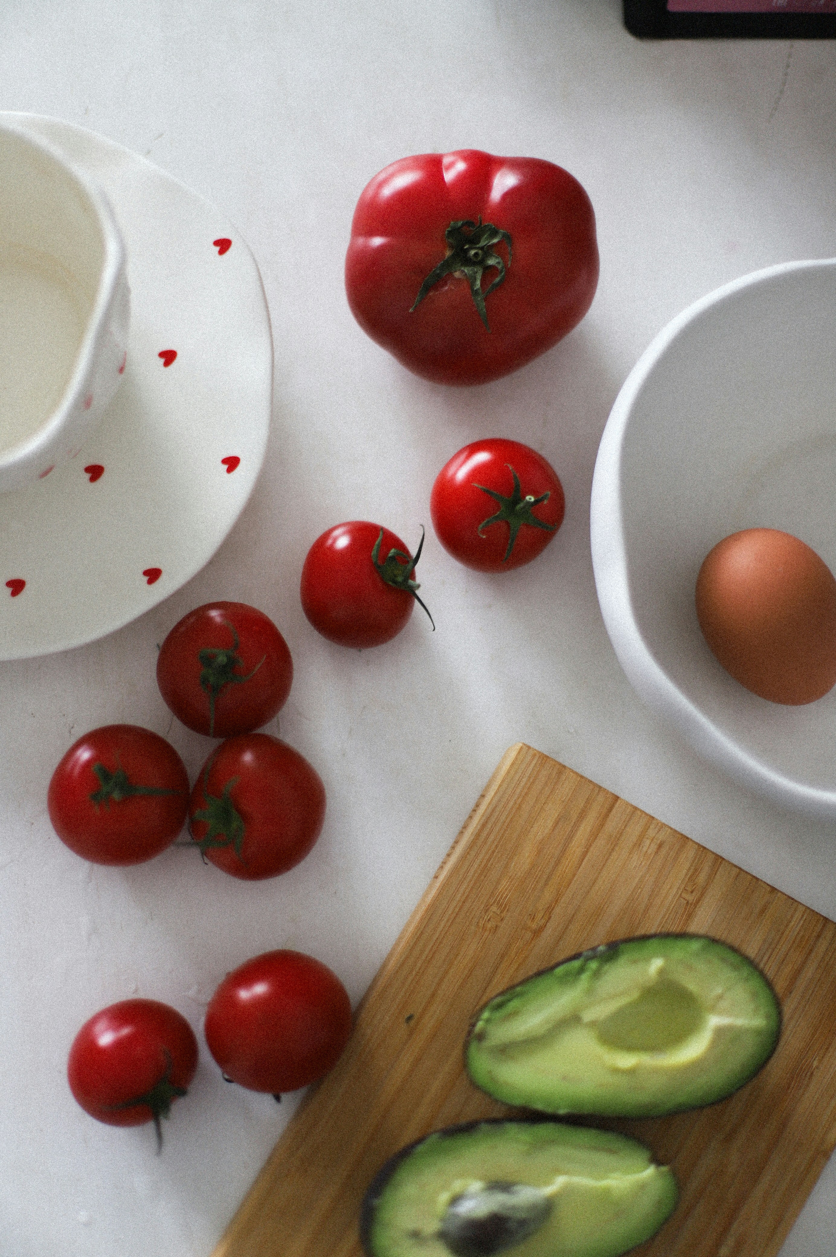 Tomatoes on a Marble Kitchen Canvas with Half-Avocado and Egg
