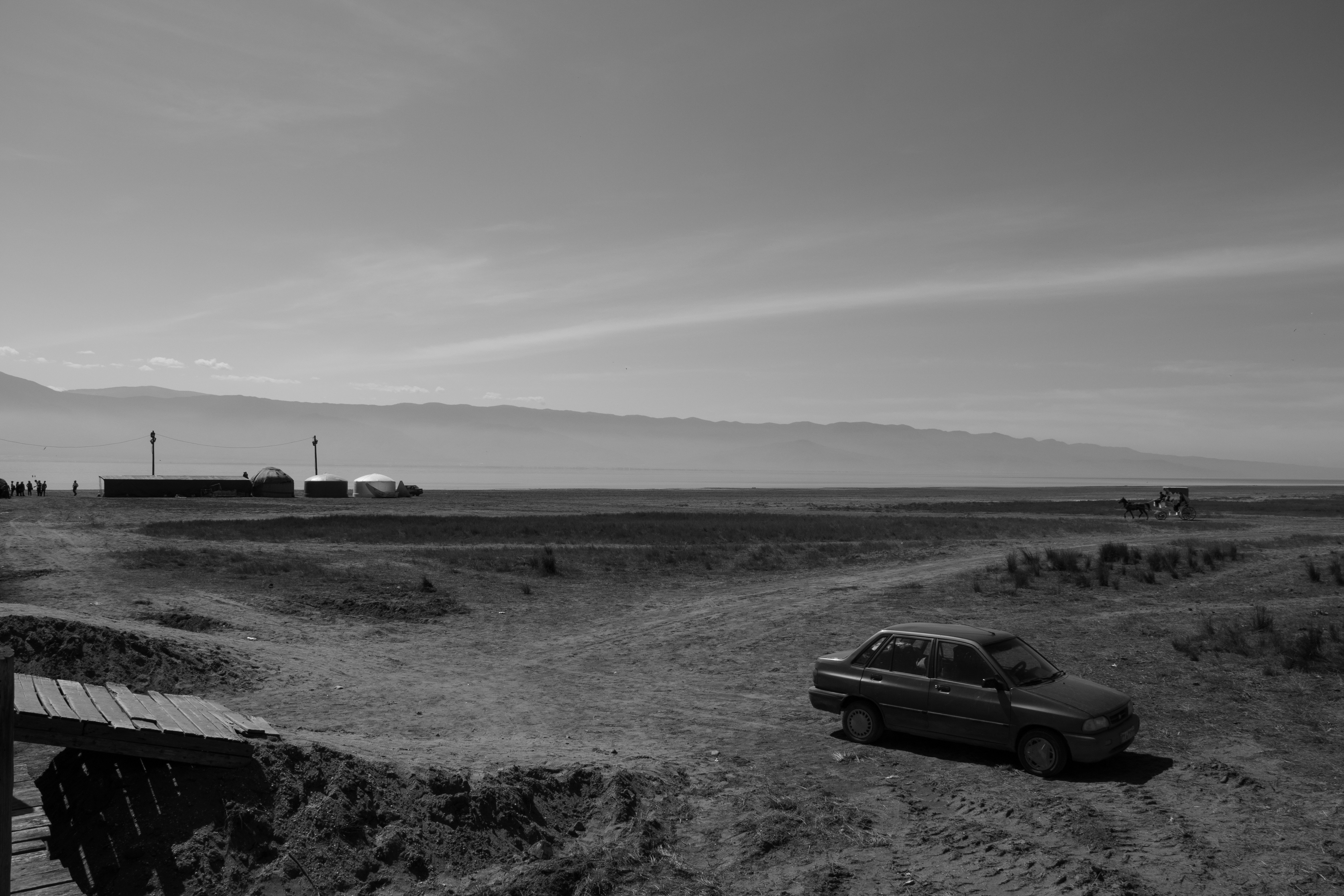 Deserted Coastline: A Quiet Car and Distant Kite of Shoreline