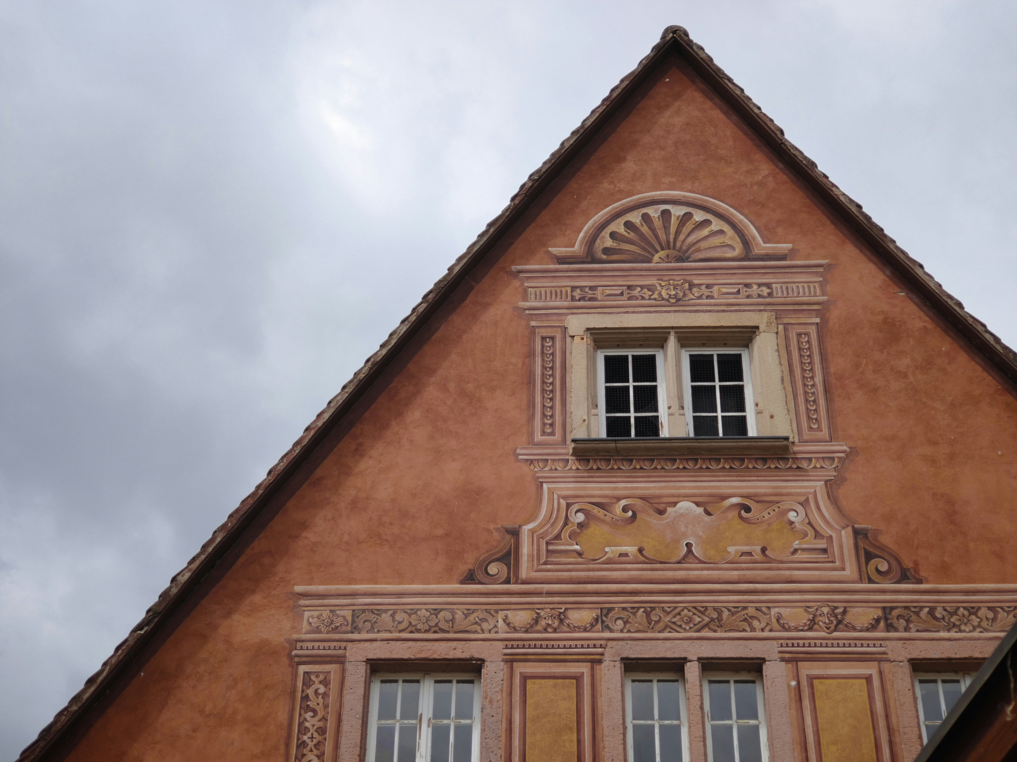 Ornate Gable Facade Under Cloudy Sky