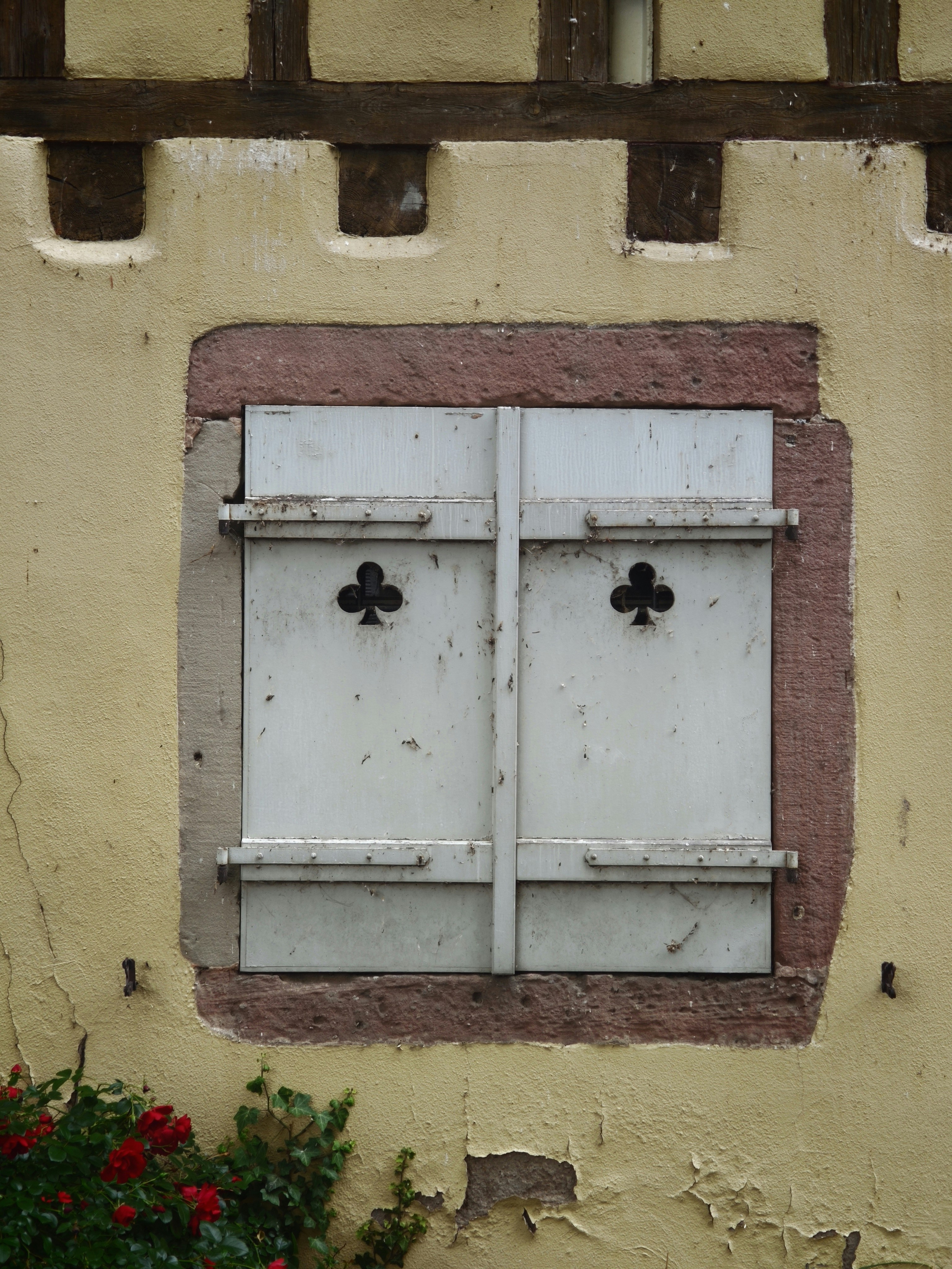 Weathered shutters in a sunlit village wall