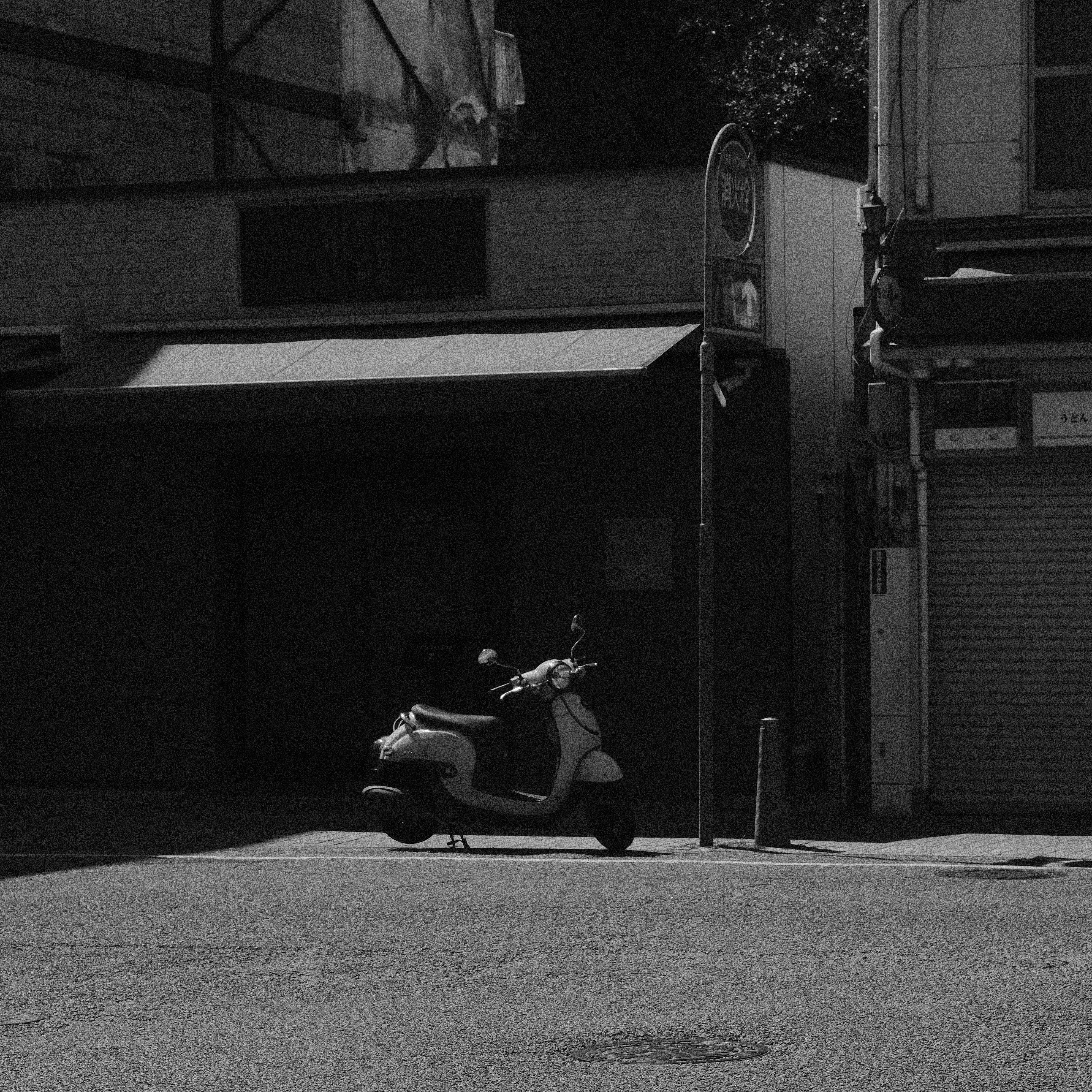 Quiet Scooter in the Shade of a Narrow Urban Street